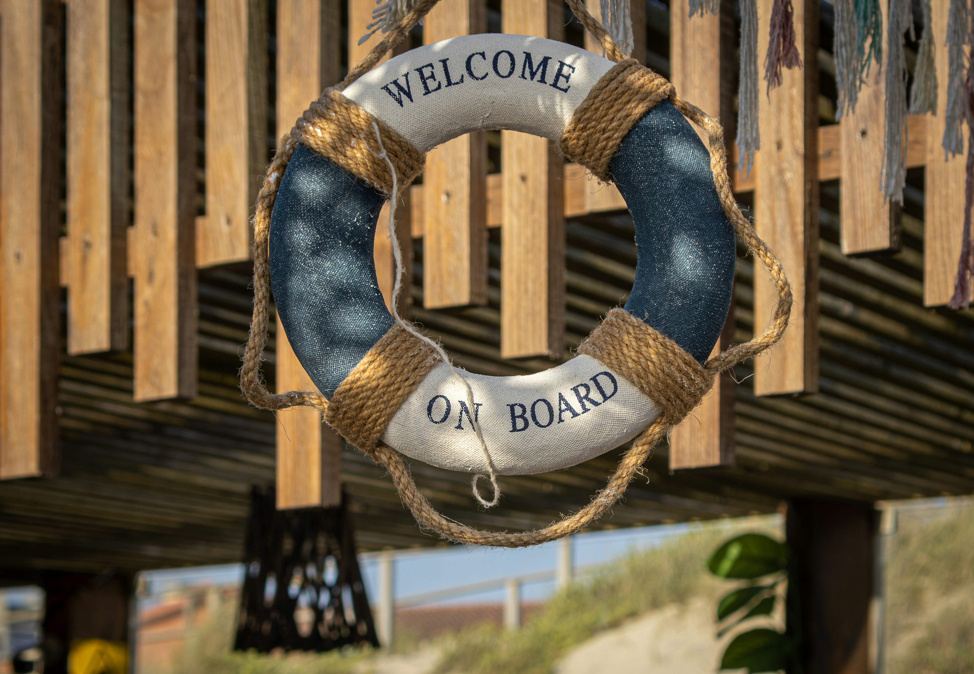 Welcome Aboard lifebuoy under a wooden deck
