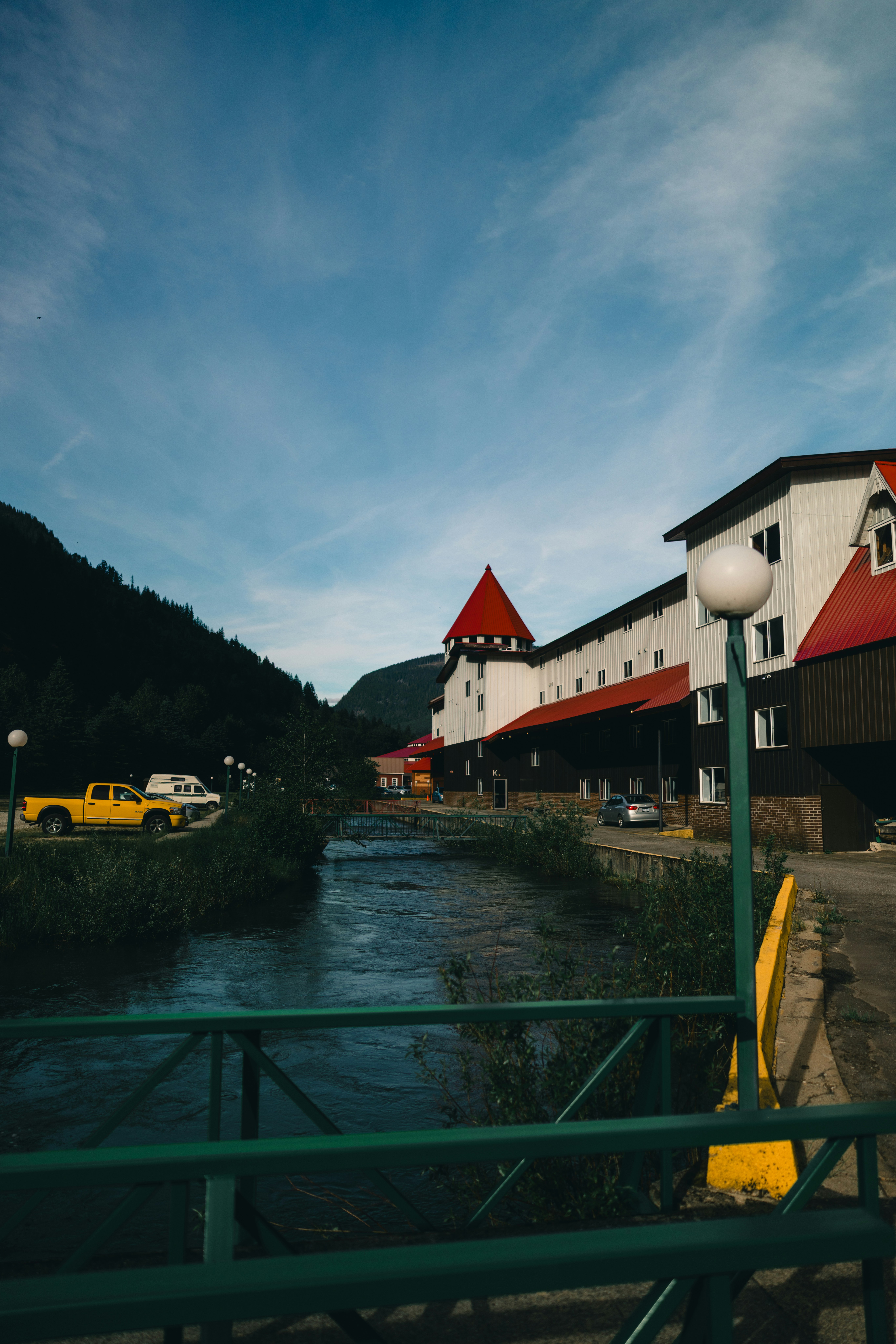 We need more road trips to Revelstoke | A river flows by buildings and mountains.