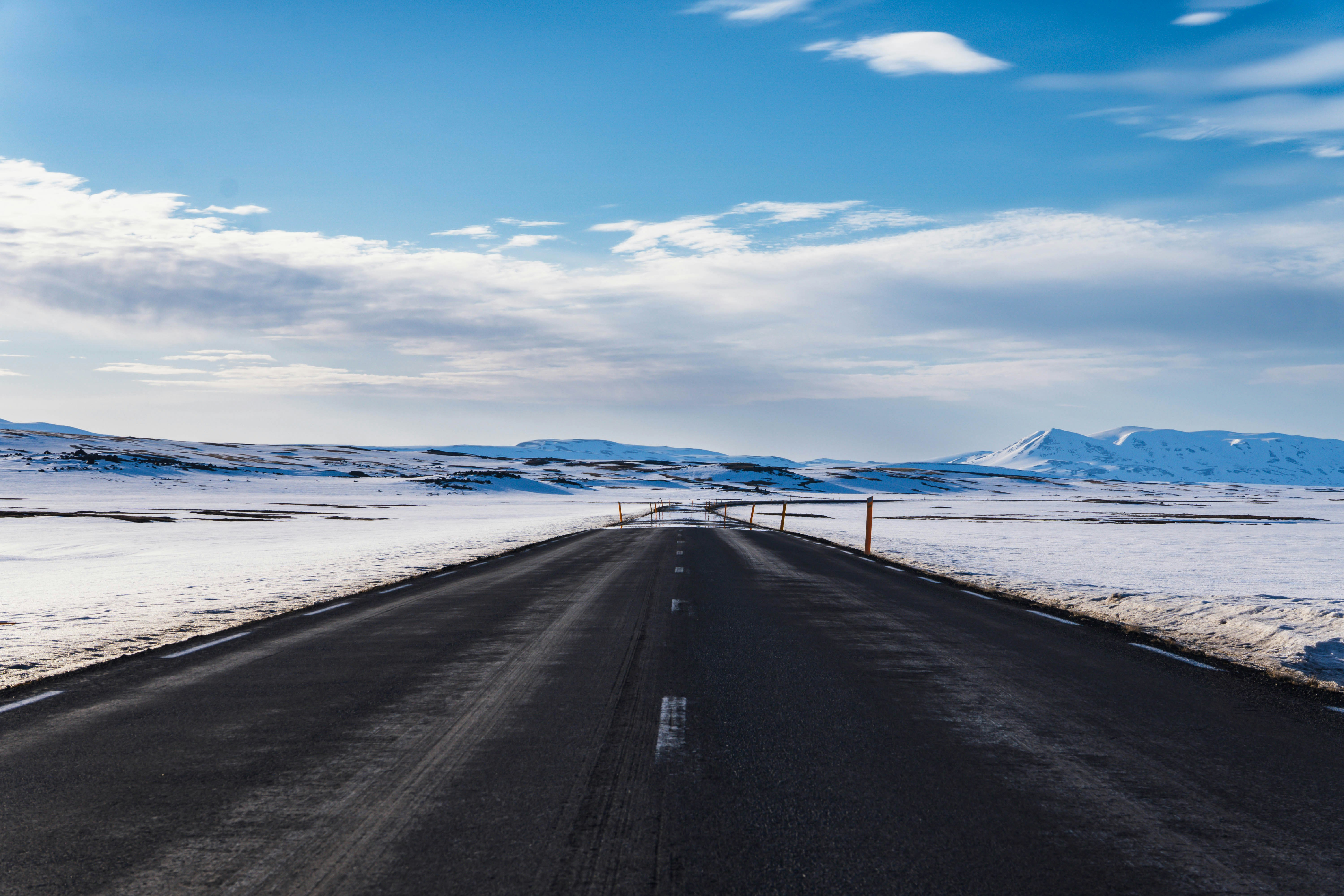 A road stretches through a snowy, scenic landscape.