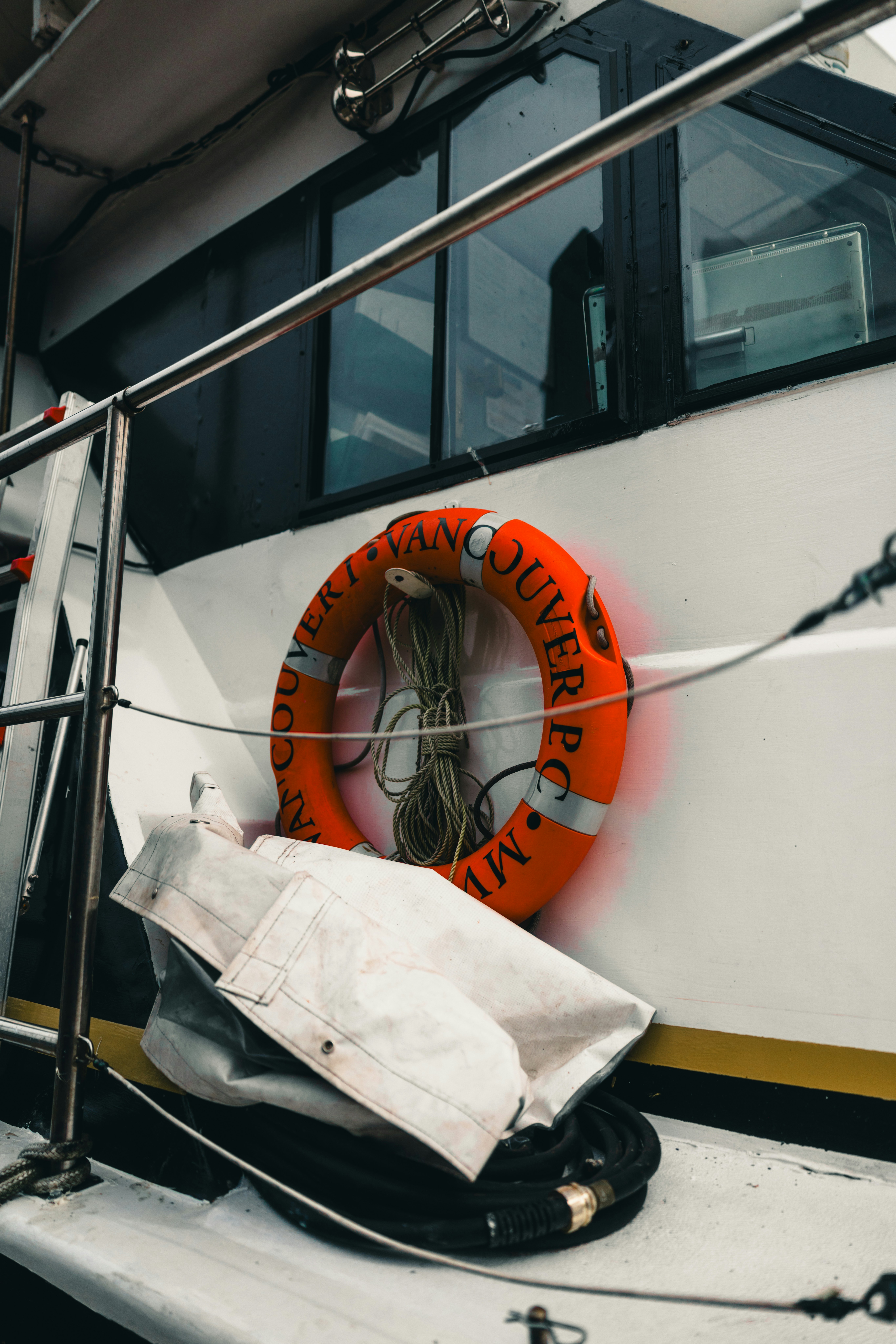 Orange Lifebuoy Framed by Coiled Rope on a Docked Vessel