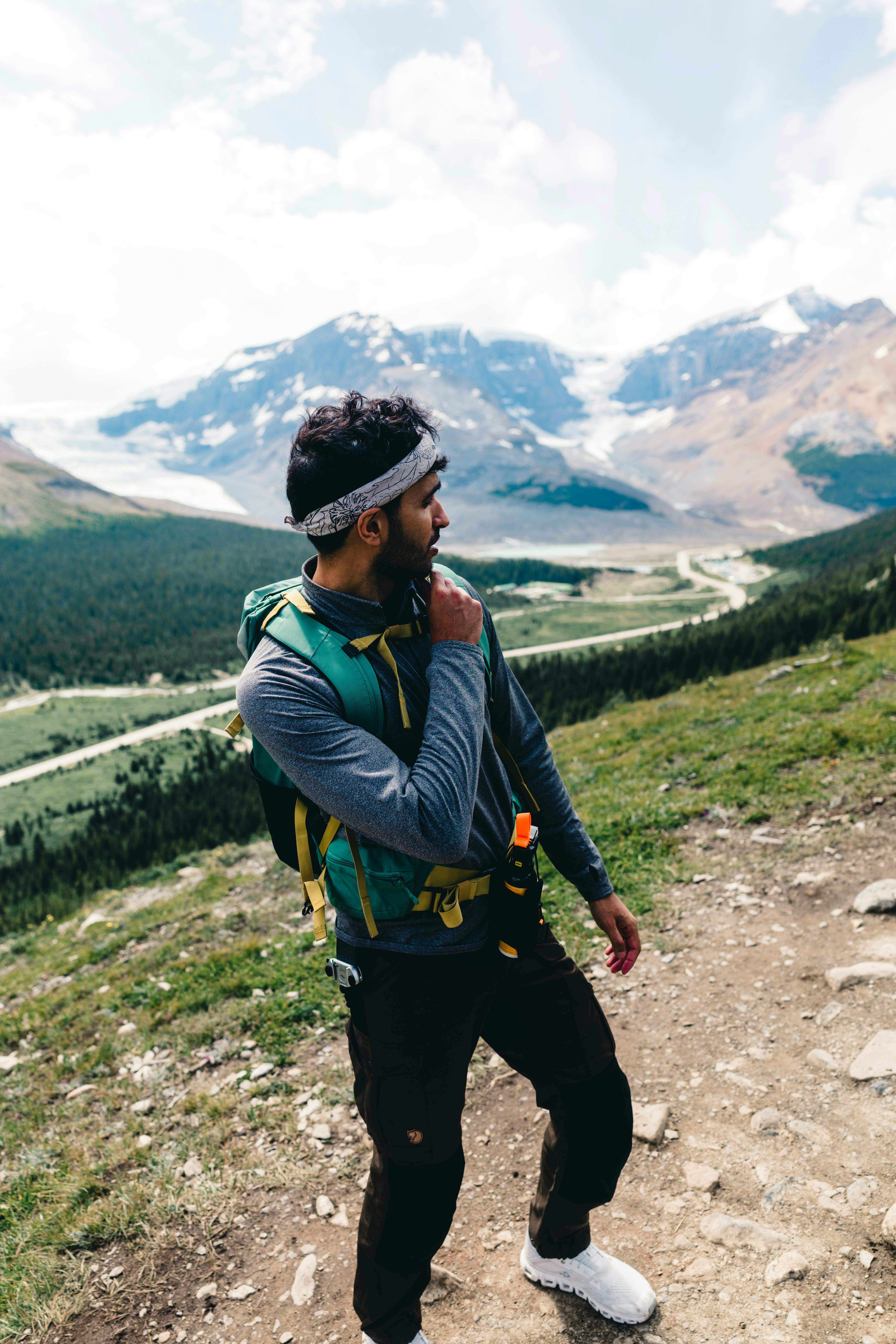 Jasper is my favourite park in Canada | Hiker stands on a mountain looking at the scenery.