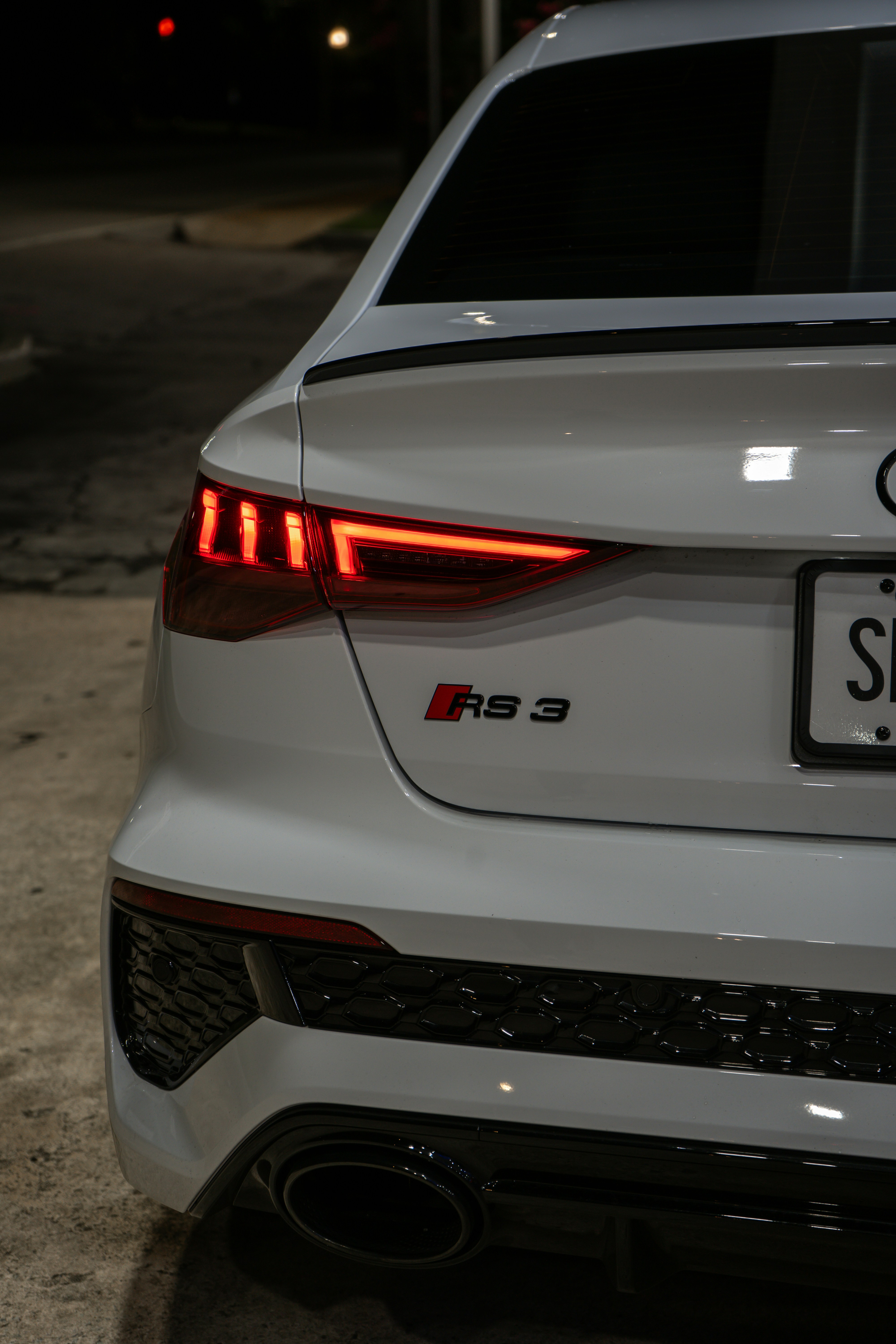 RS 3 at Night: A White Audi's Rear Glow and Sculpted Contours