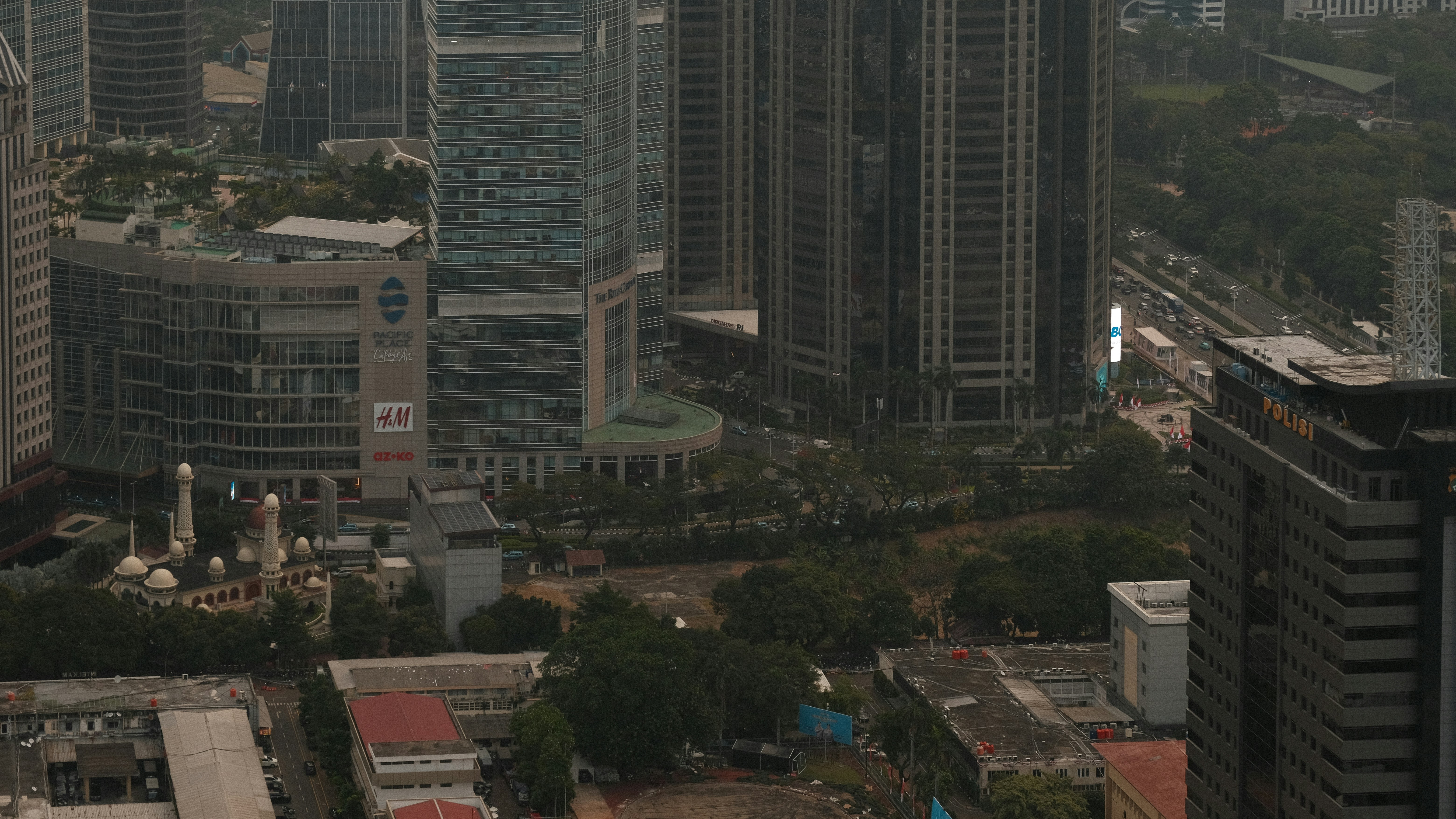 Cityscape with tall buildings and a park.