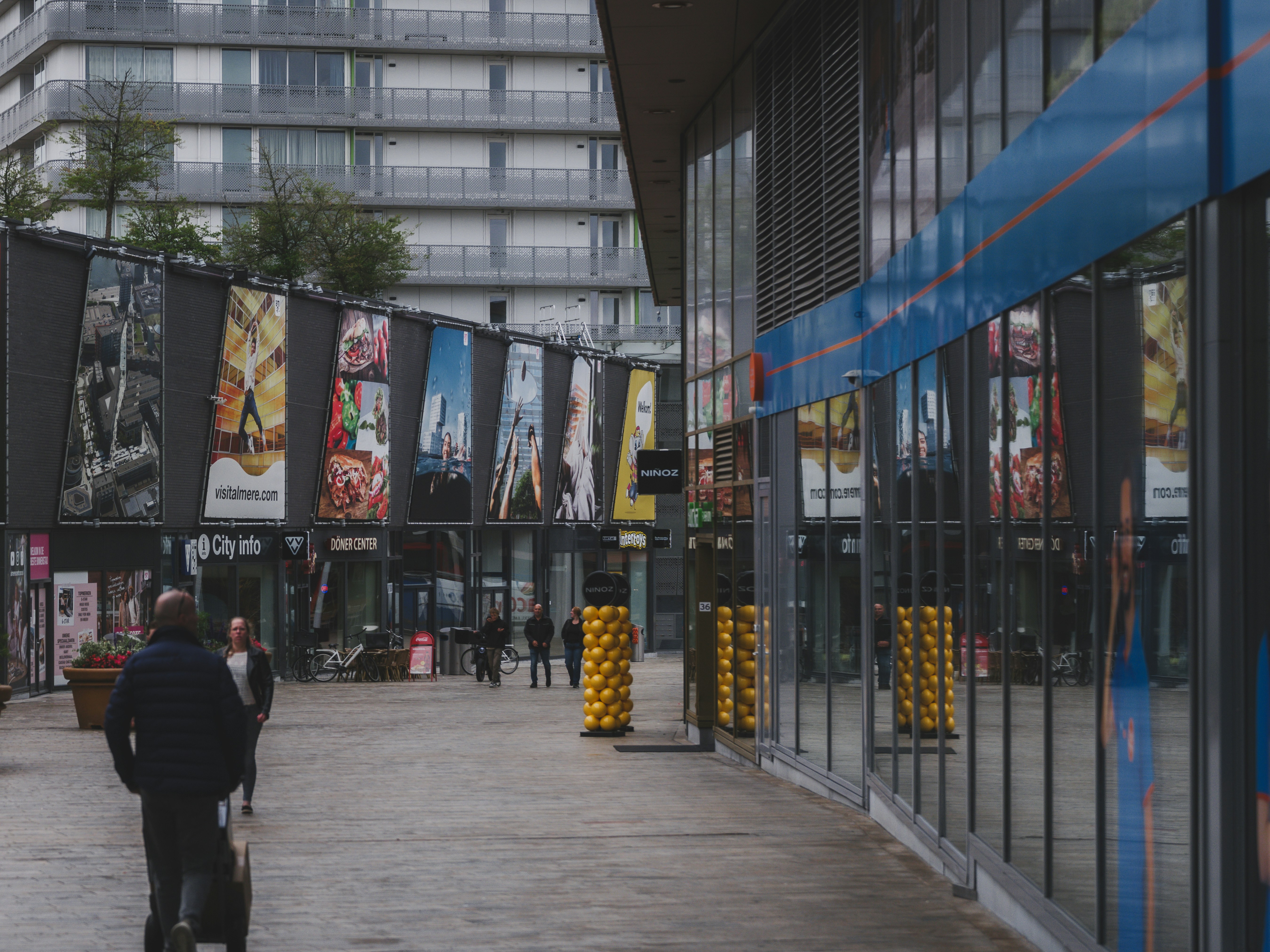 Urban Gallery Walk: Posters Framing a Glass-Faced Plaza