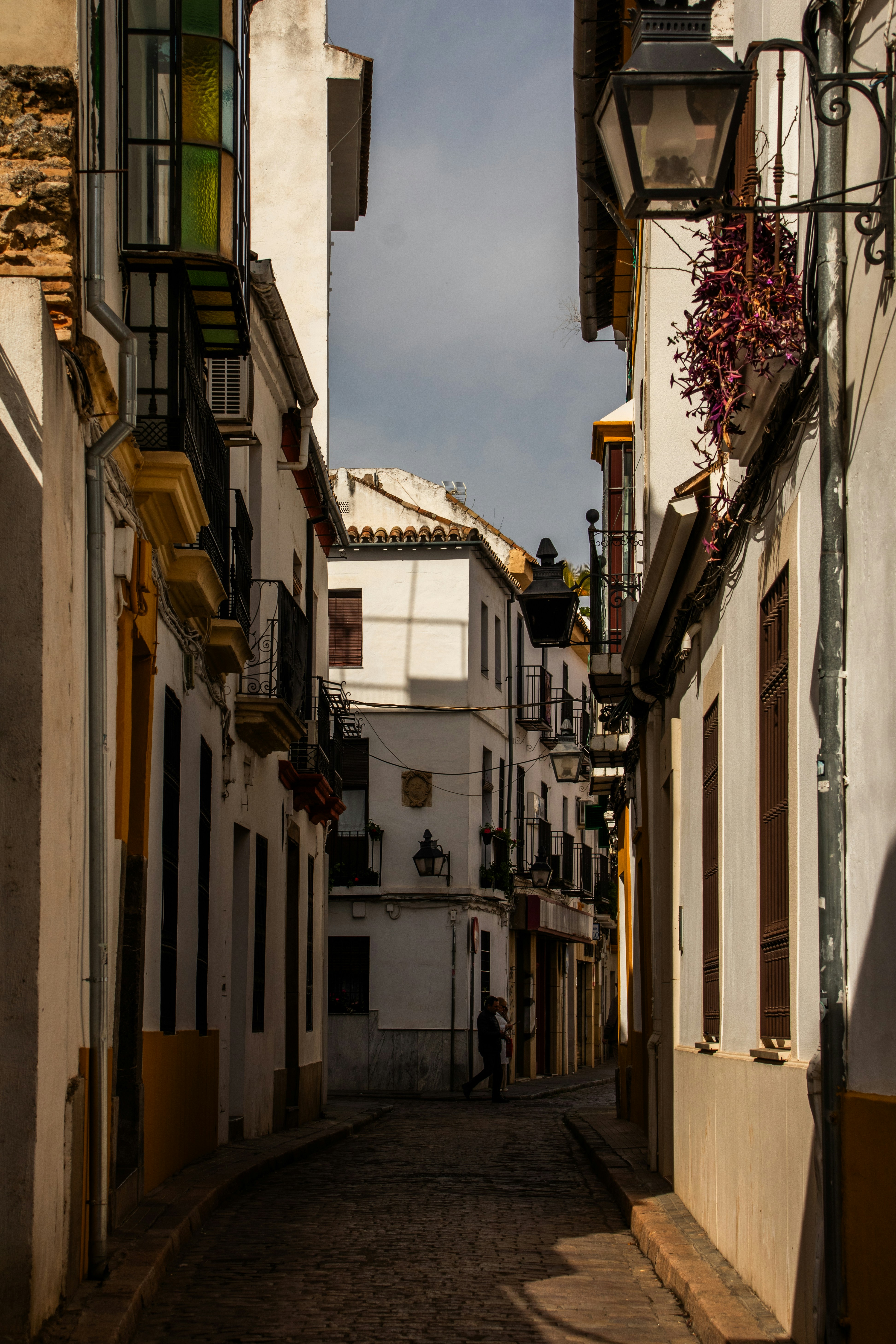 Narrow european street with white buildings.