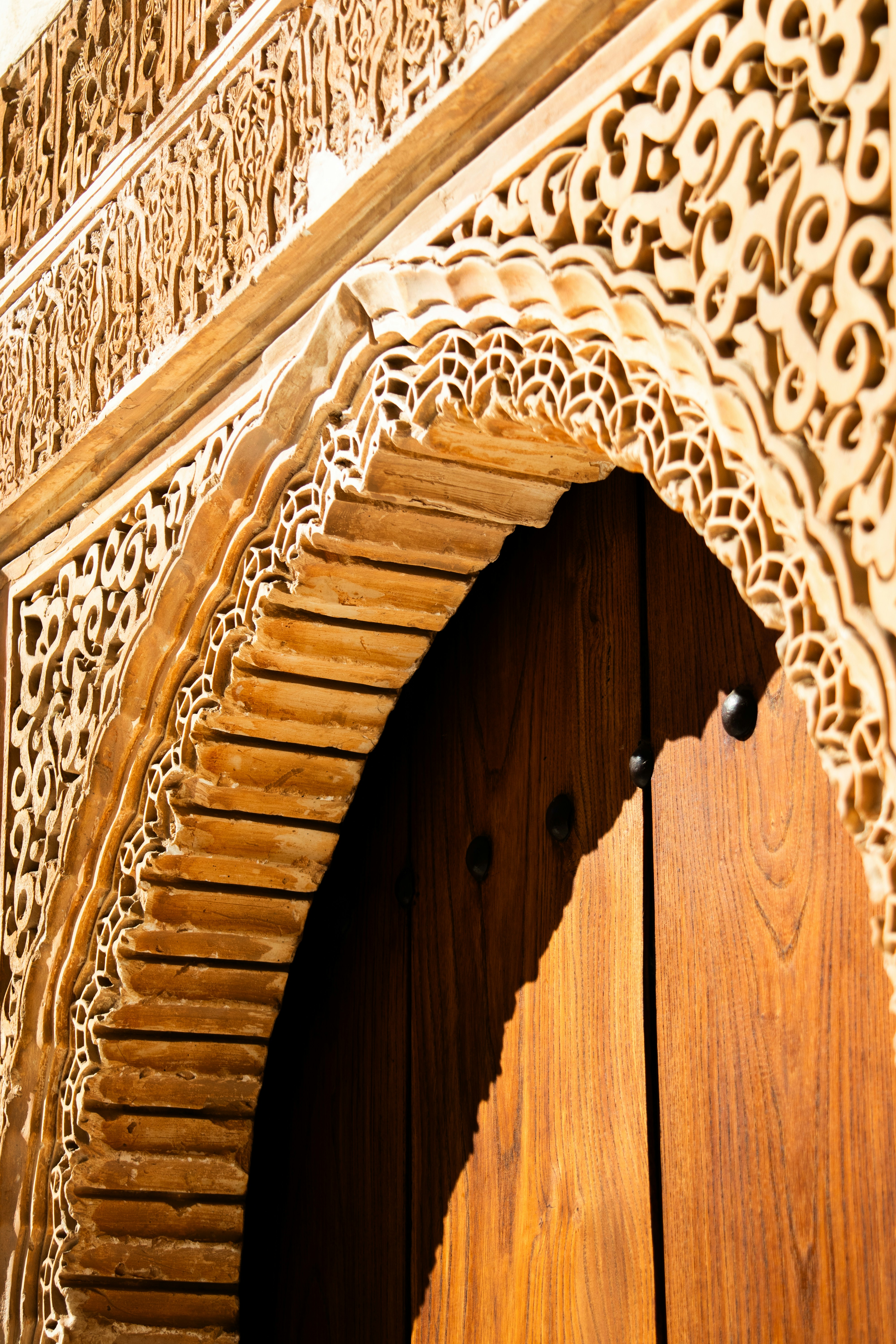 Intricate archway and wooden door with carvings.