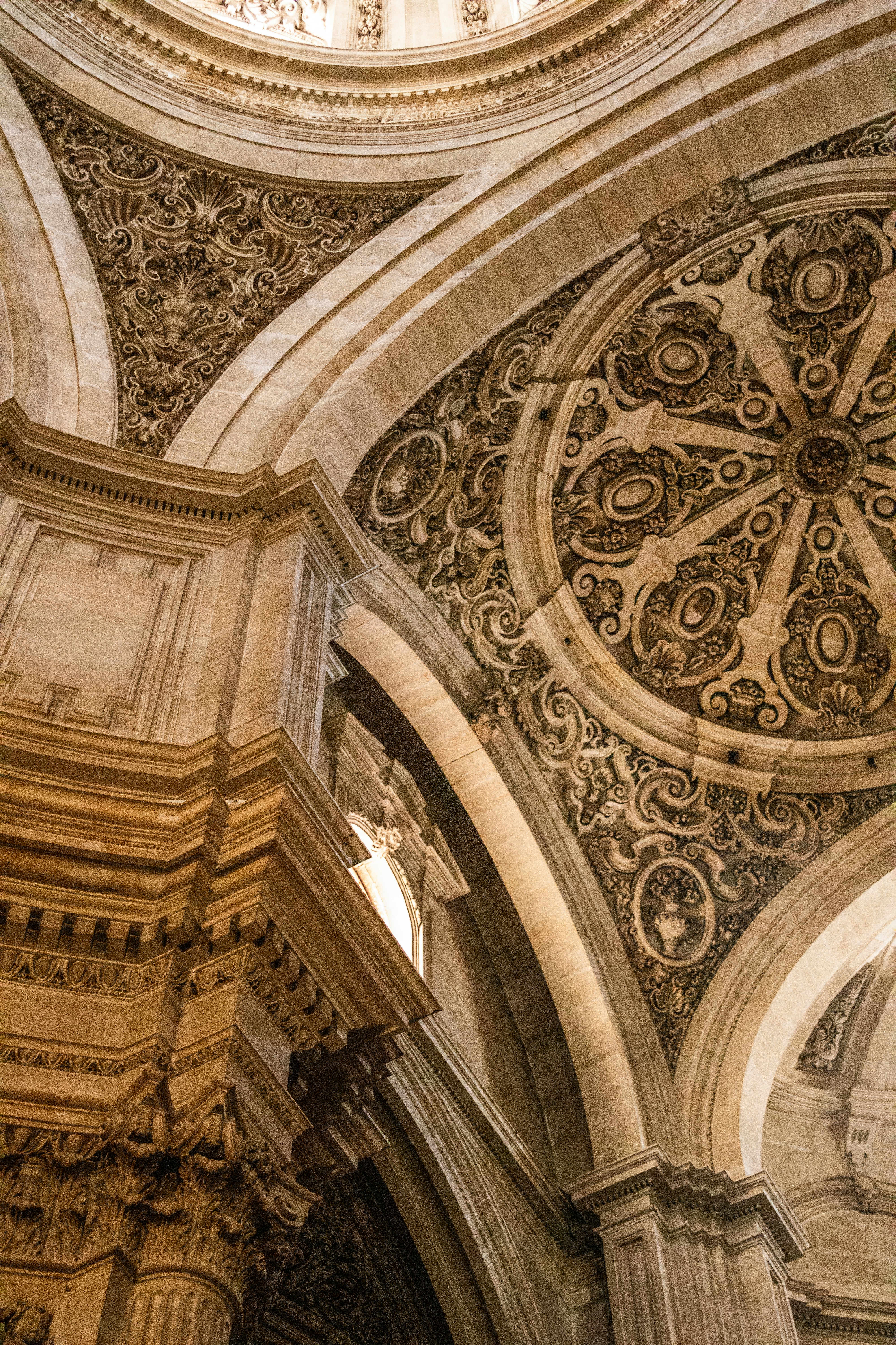 Intricate ceiling details and ornate columns highlight the grandeur of a historic building's interior.