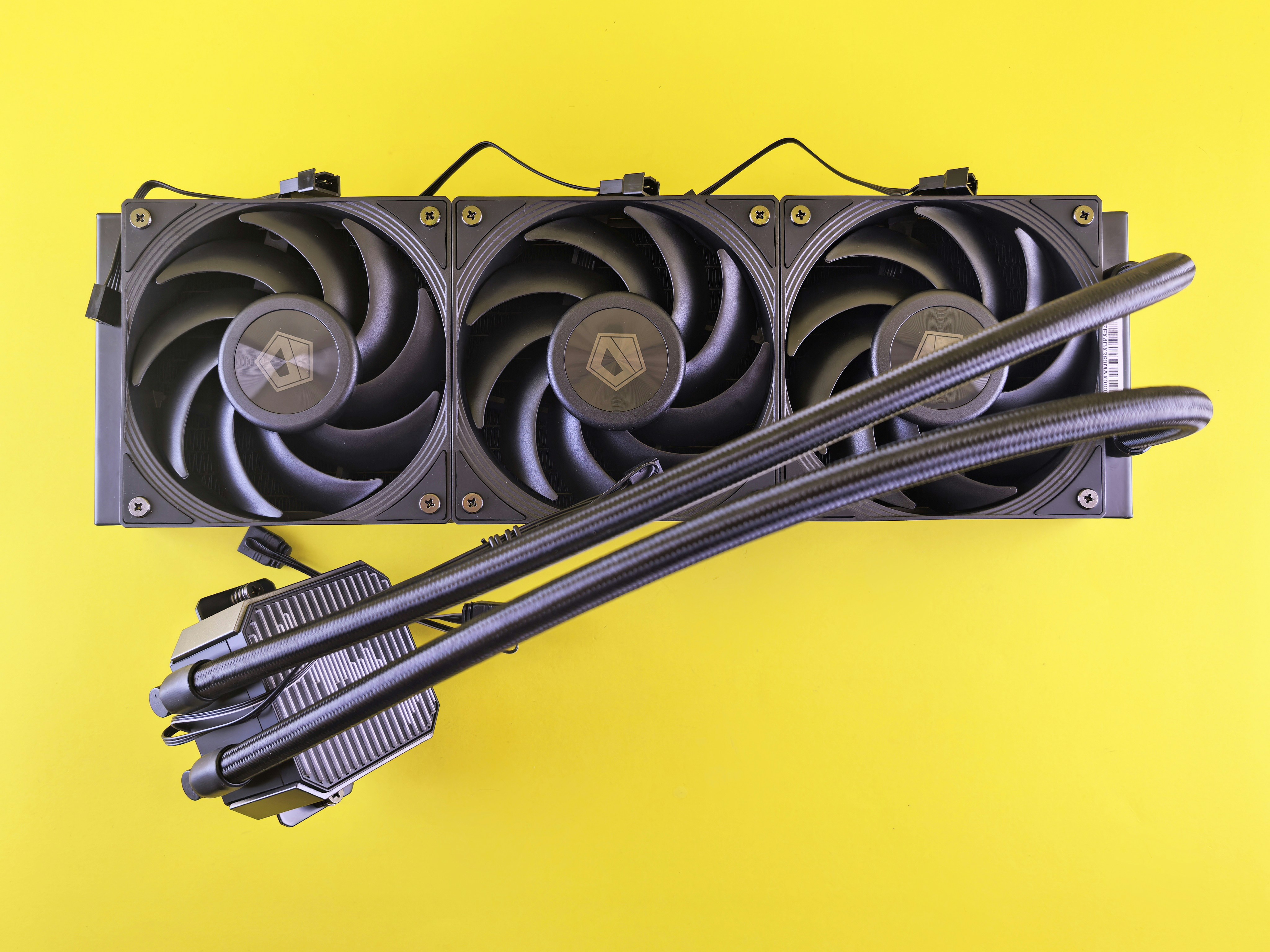 Three cooling fans and tubing on a yellow surface.