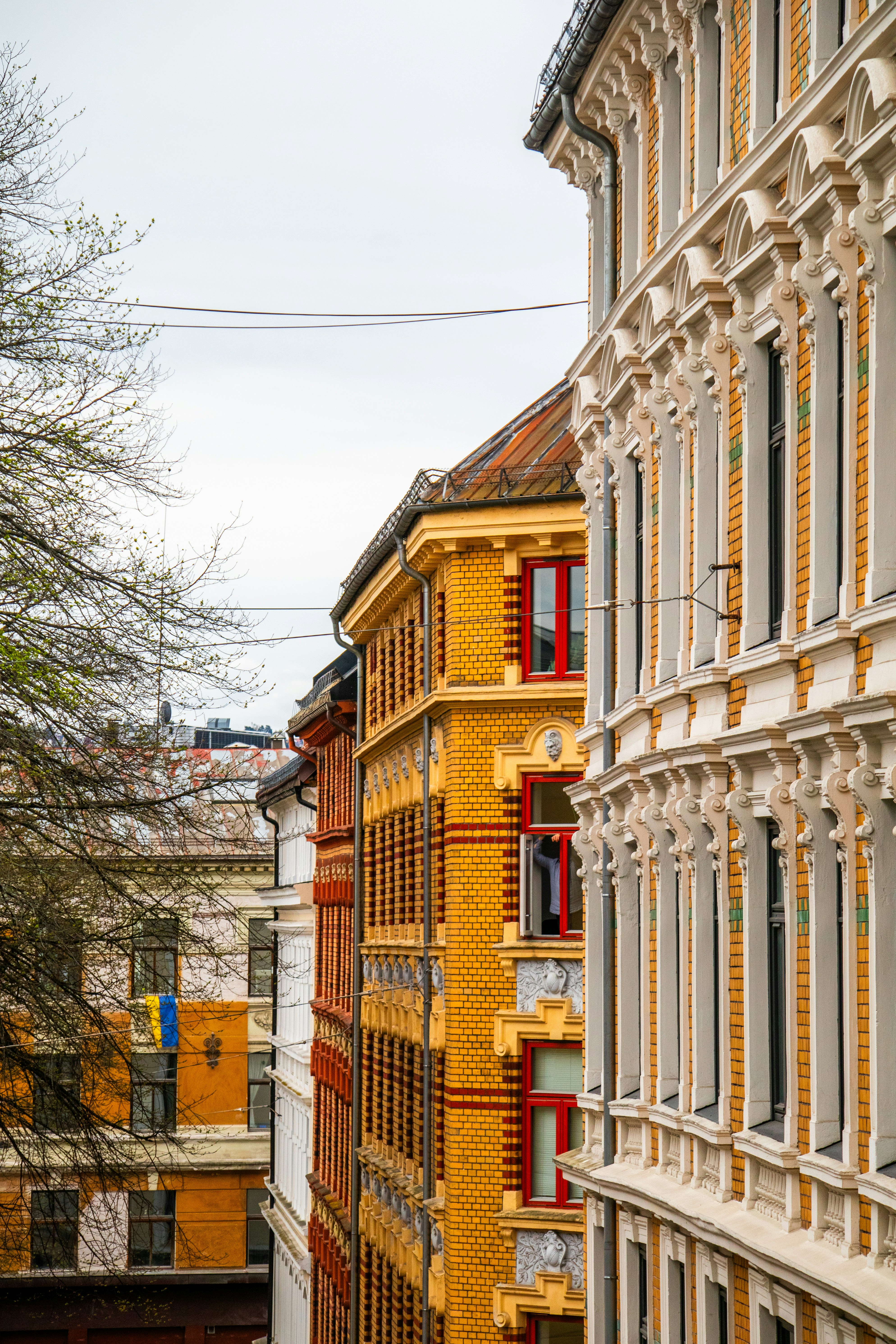 Colorful buildings juxtaposed against a cloudy sky, showcasing a blend of architectural styles in an urban setting.