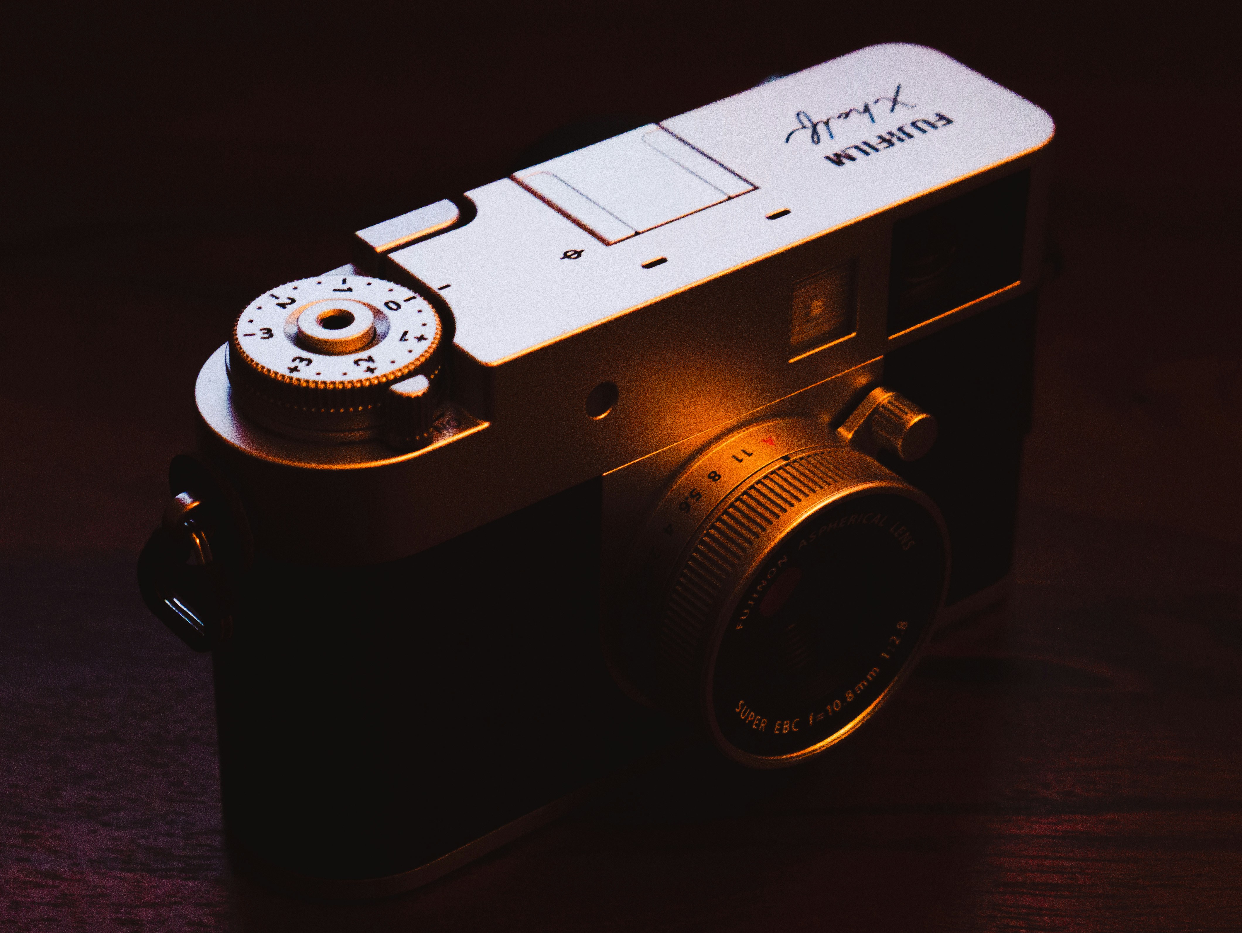 A luxurious camera is posed on a dark surface. photo – Free Tech Image ...