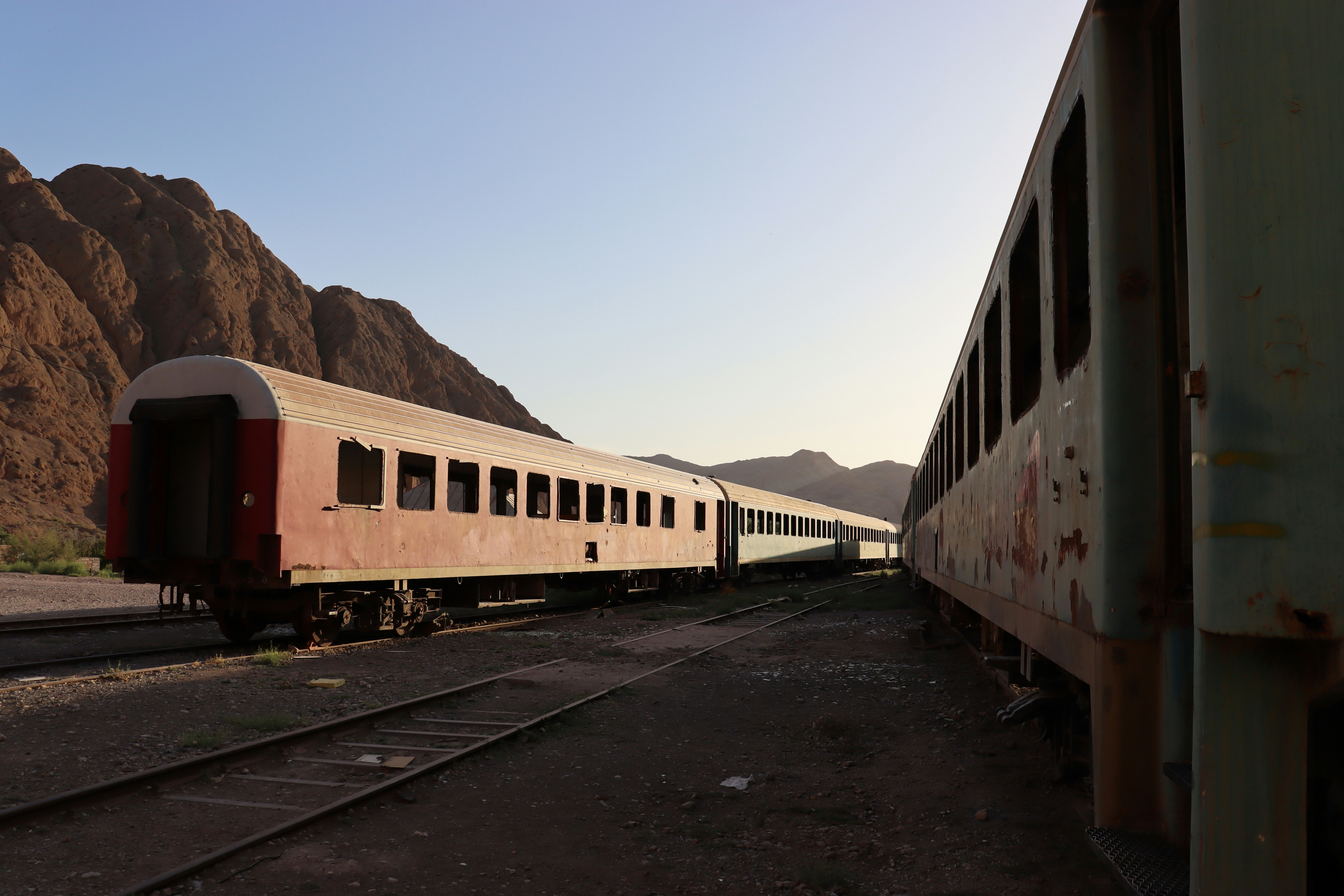 Final Stop: Trains Left Behind Simin Dasht train station Simin Dasht, Tehran, Iran | Abandoned train cars sit in a scenic setting.