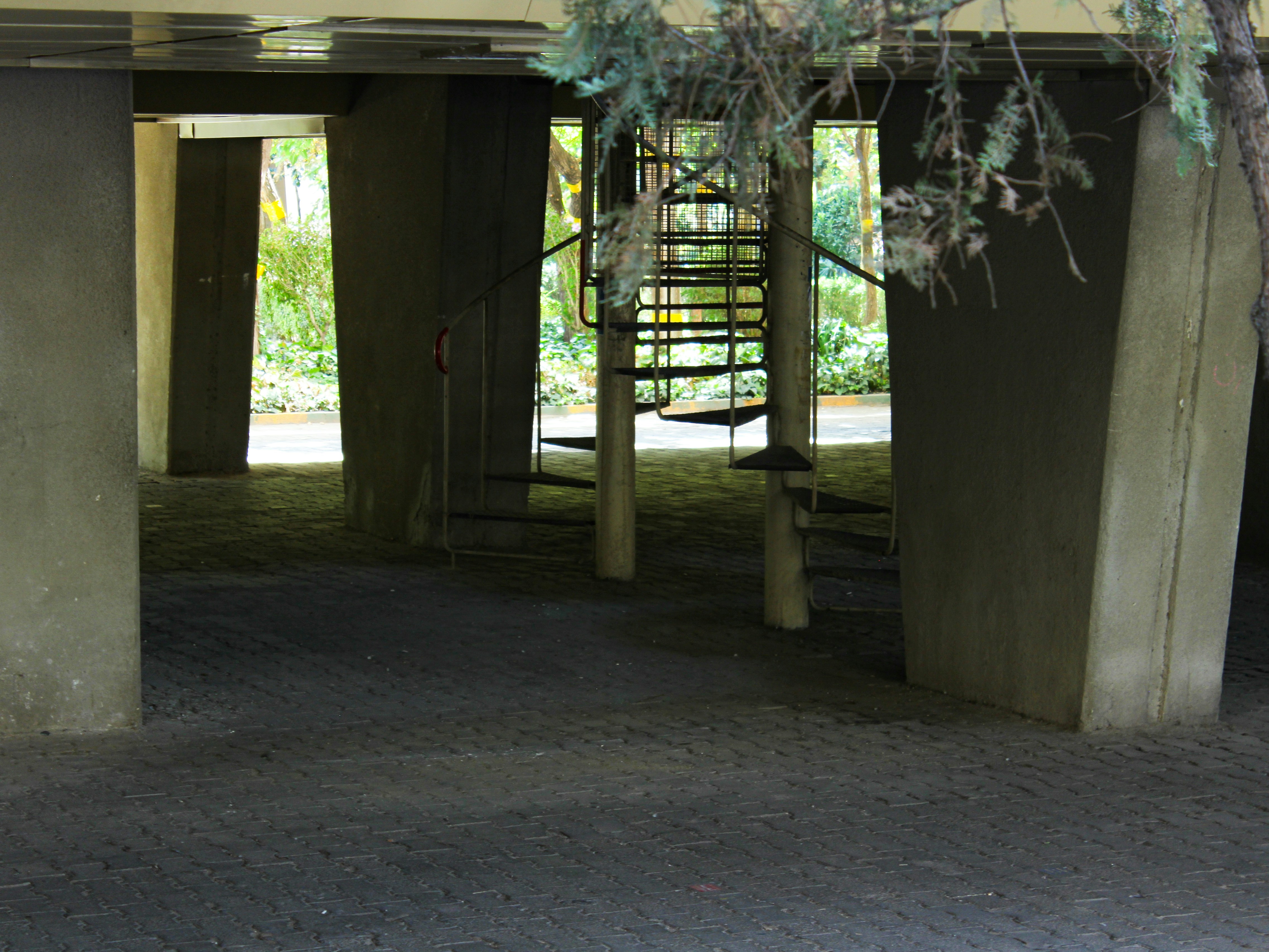 A dark space under a building with columns.