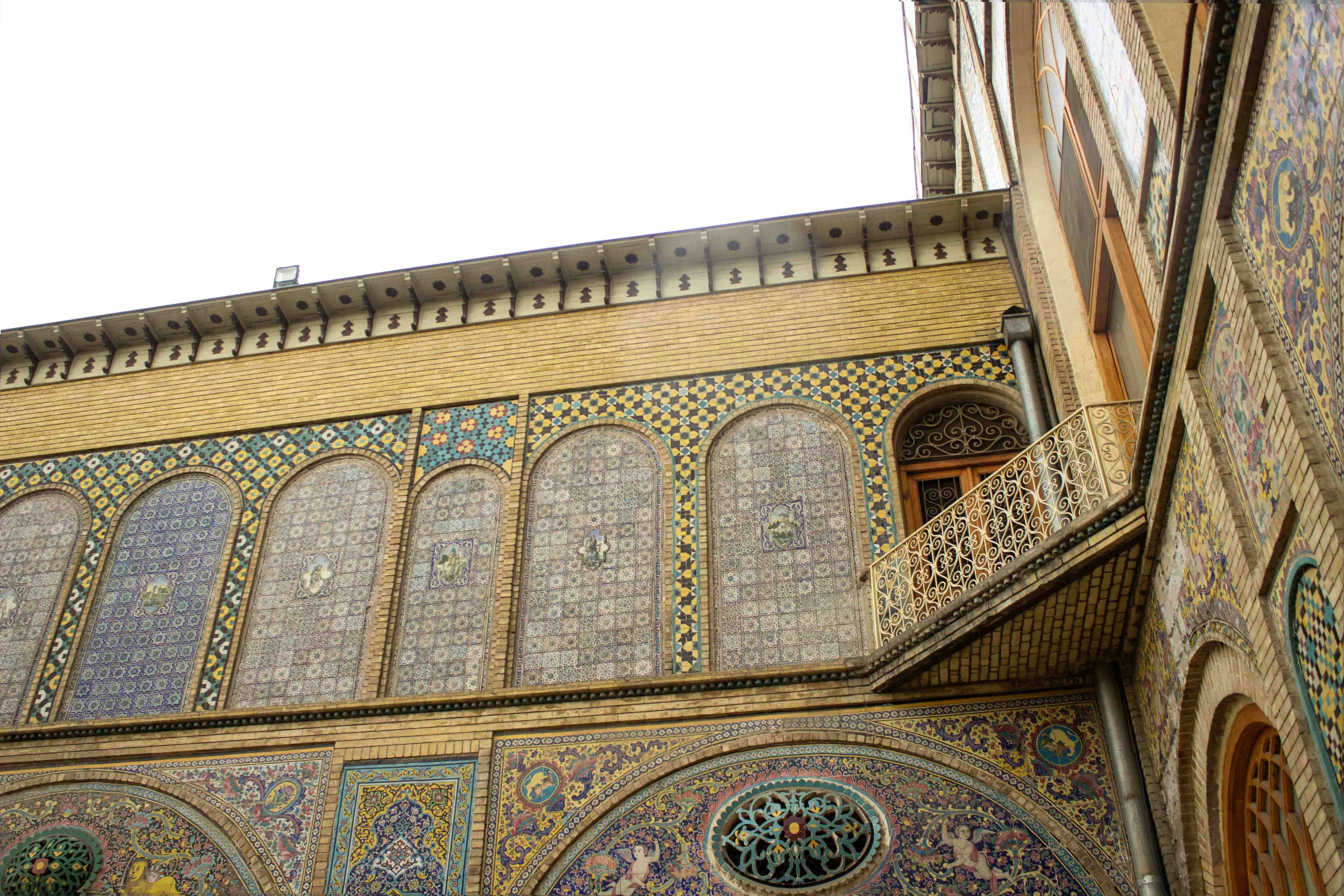 Intricate, tiled building exterior with an outdoor balcony.
