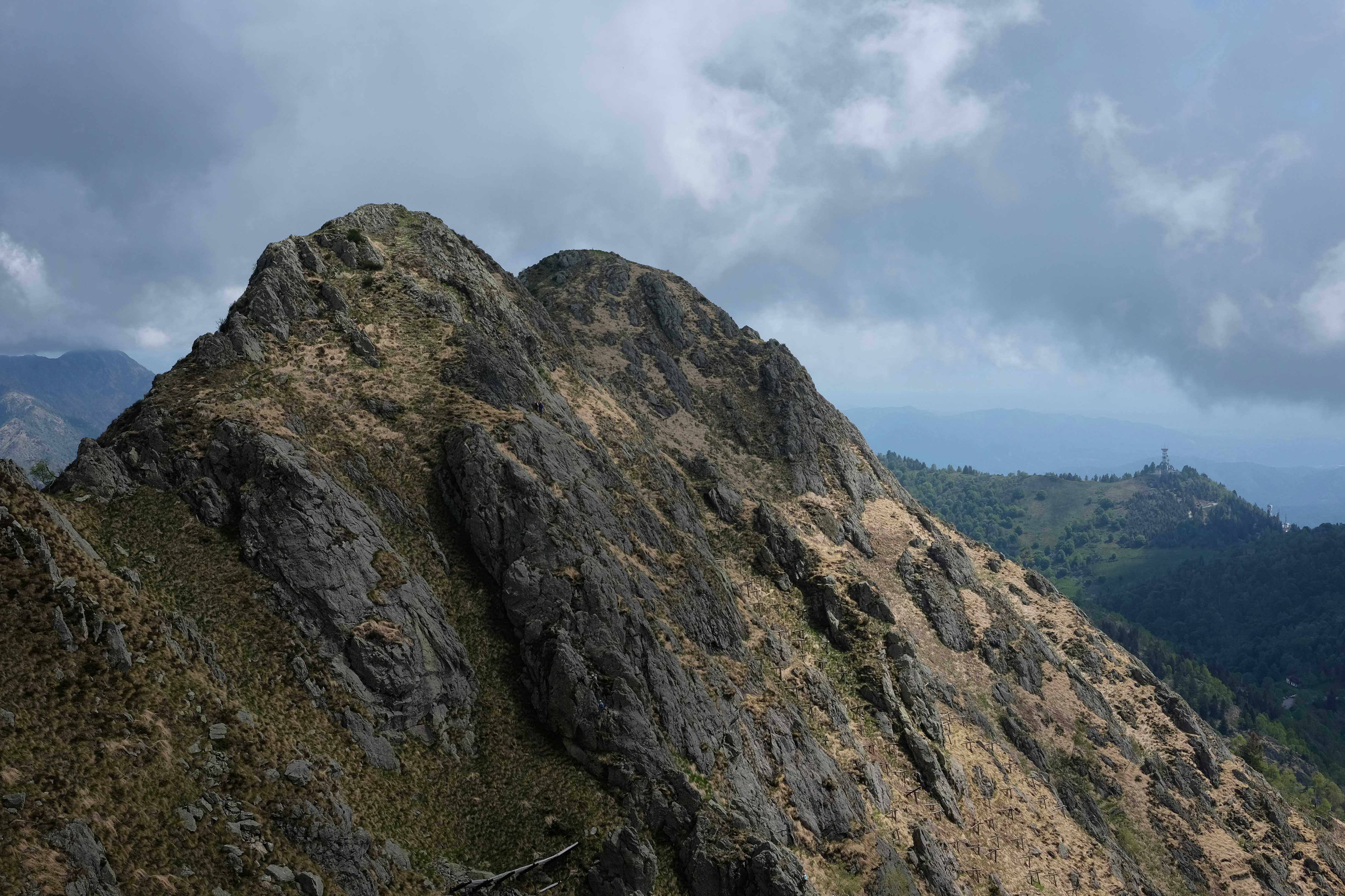 A rocky mountain peak under a cloudy sky.