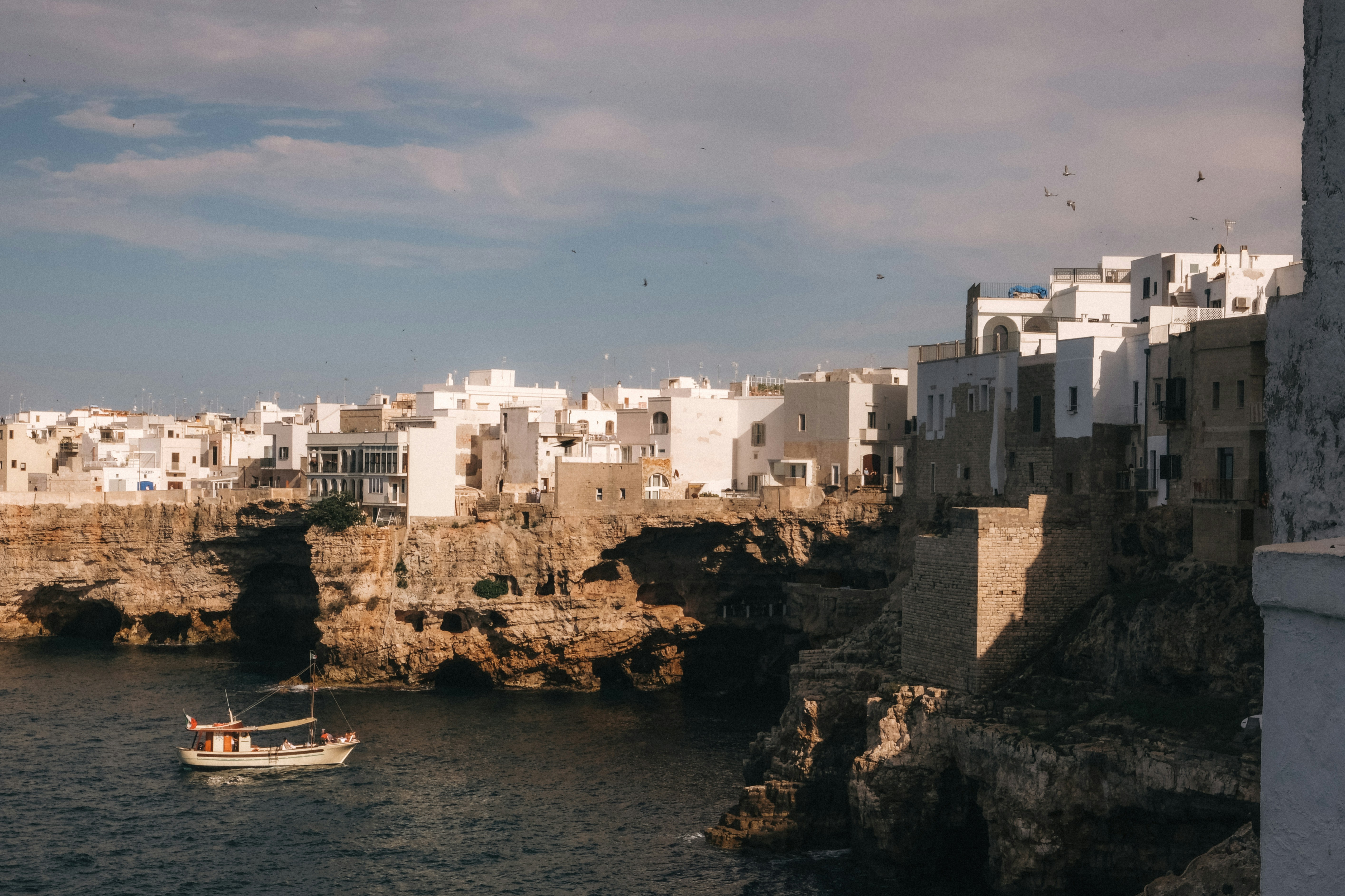A coastal town with white buildings and a boat.