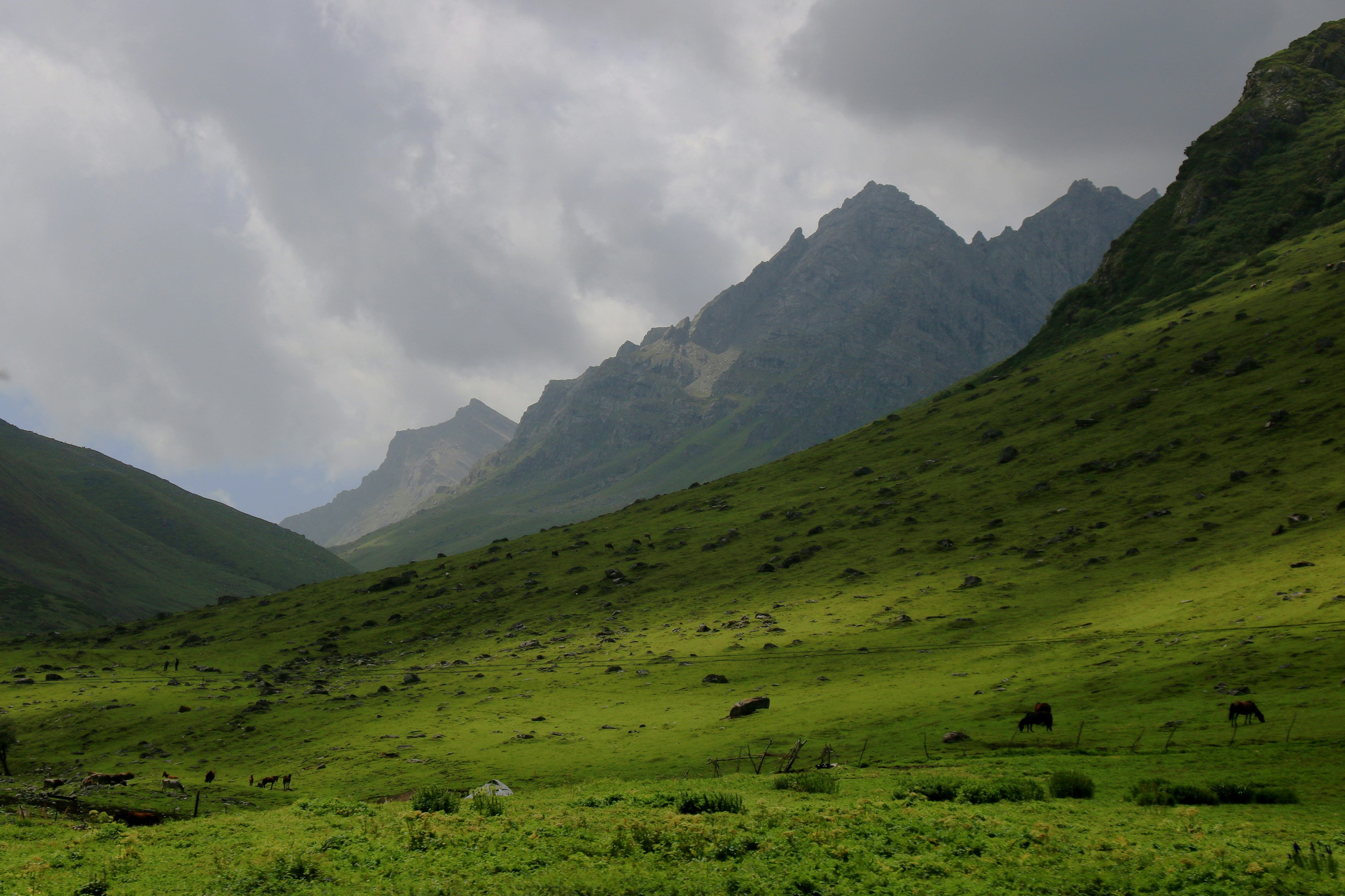 Filmed in Xinjiang | Green mountains loom under cloudy skies.