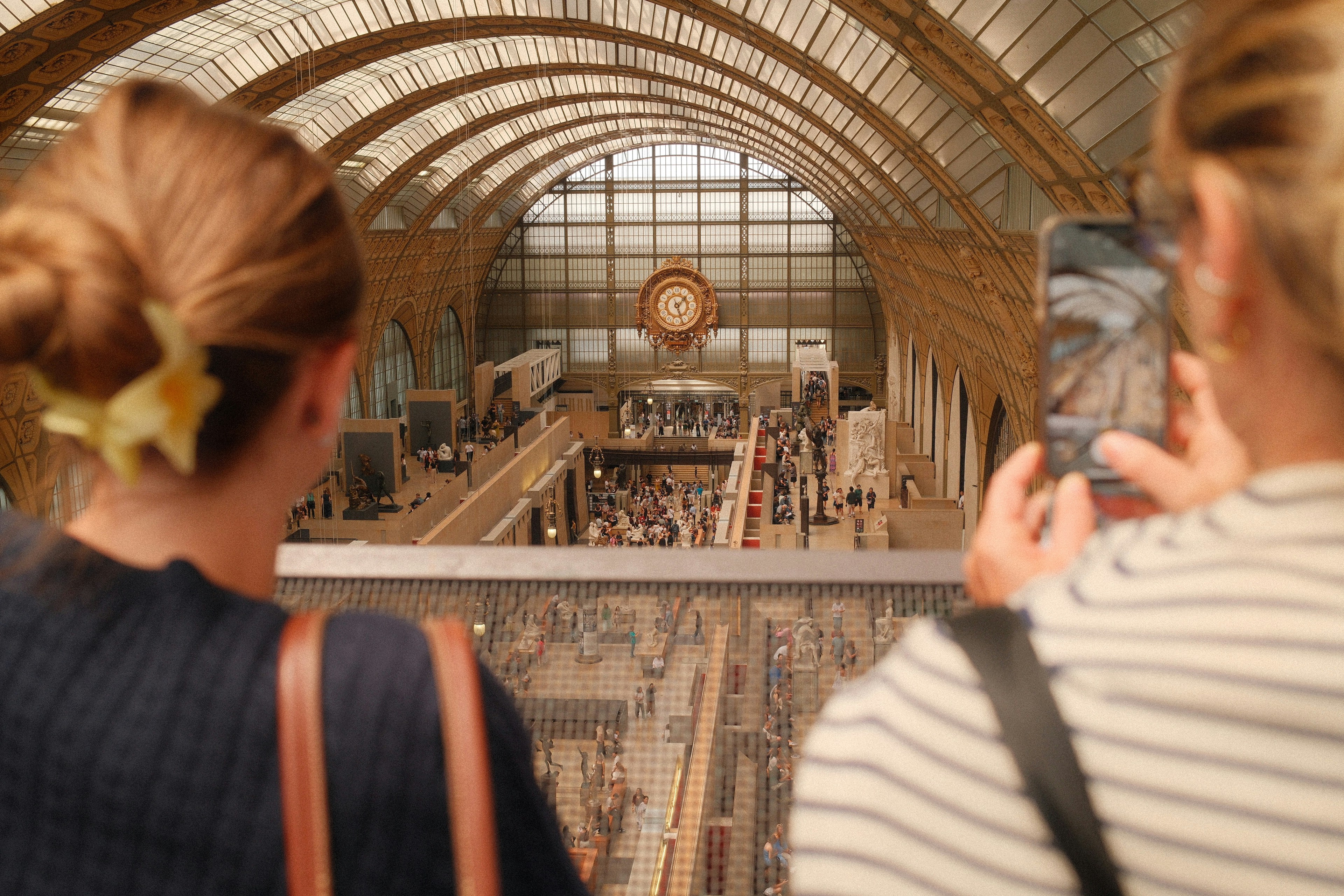 Musée d’Orsay | Two women enjoy the interior view of a museum.