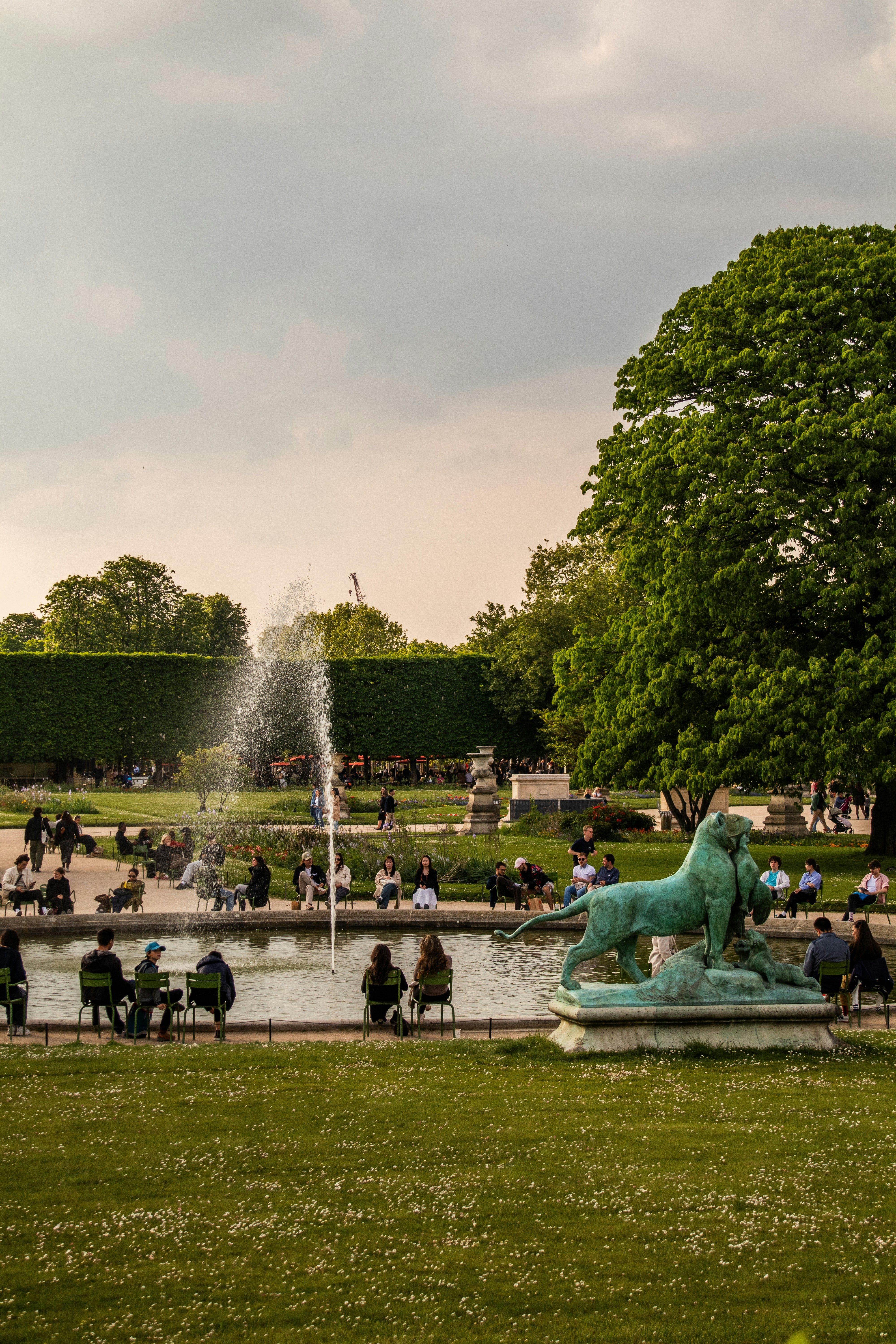 People relax in a park near a fountain.