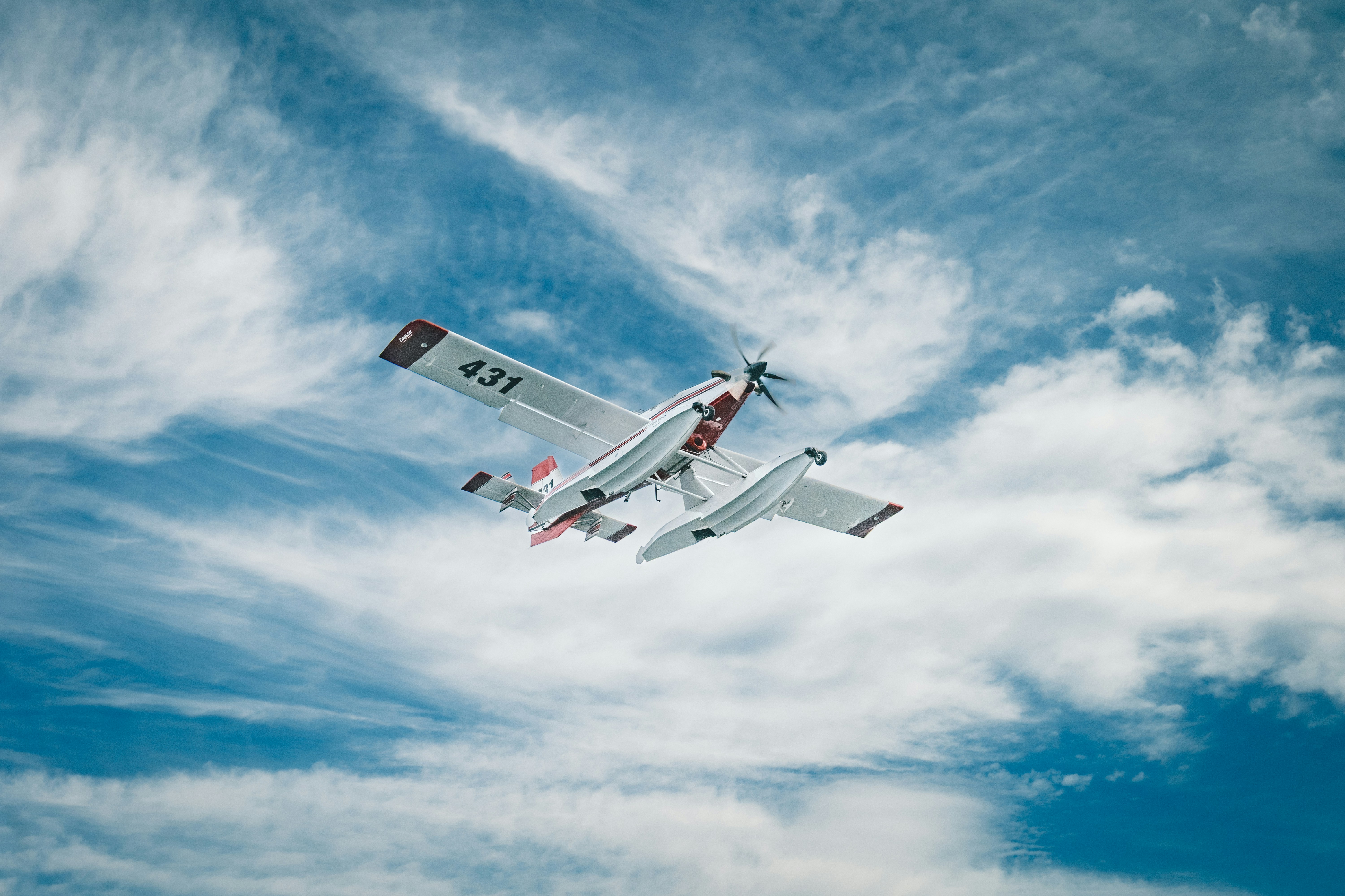 Aerial Firefighting Plane in Flight Against Cloudy Sky | A seaplane soars gracefully through the sky.