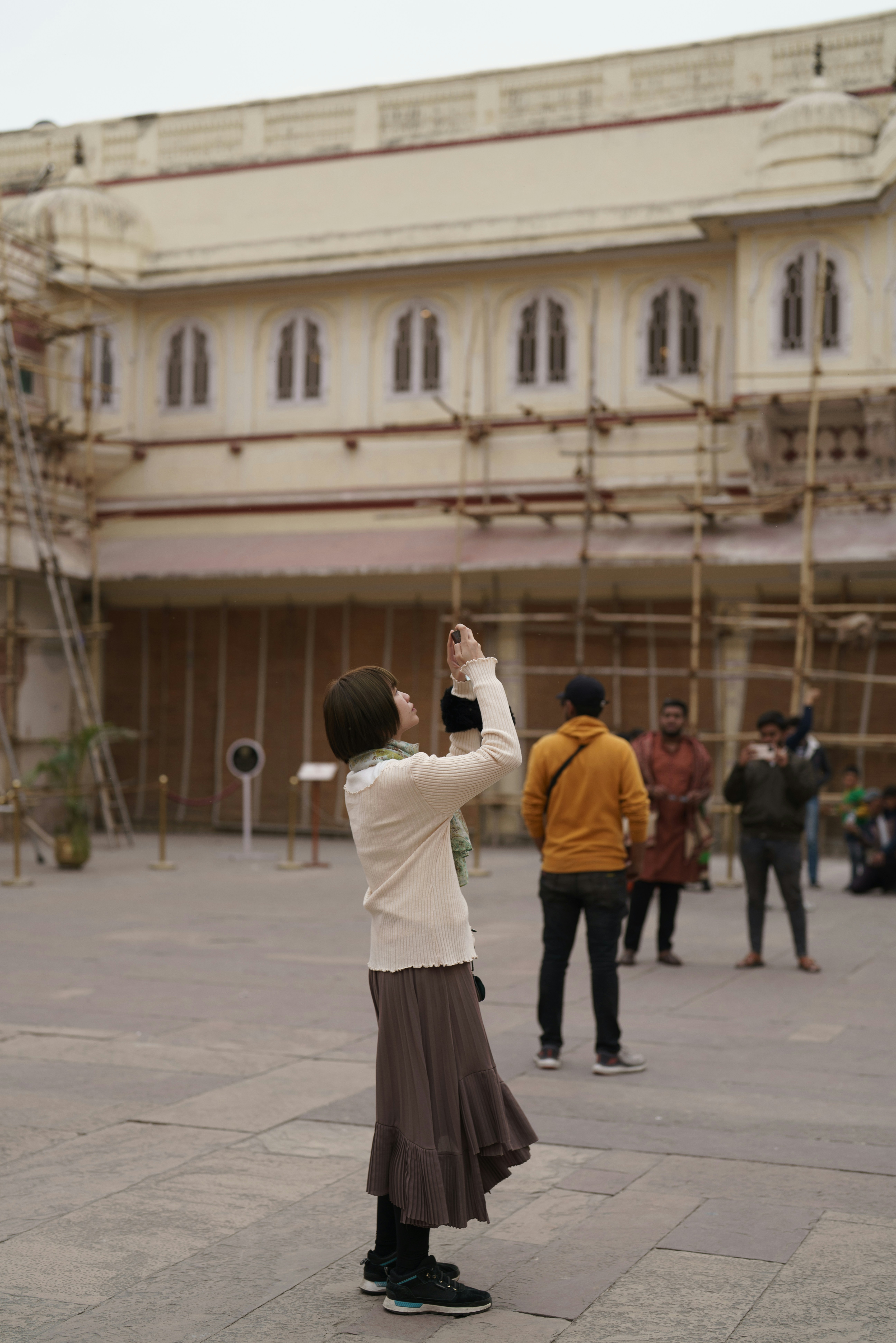 A woman takes photos of a building.