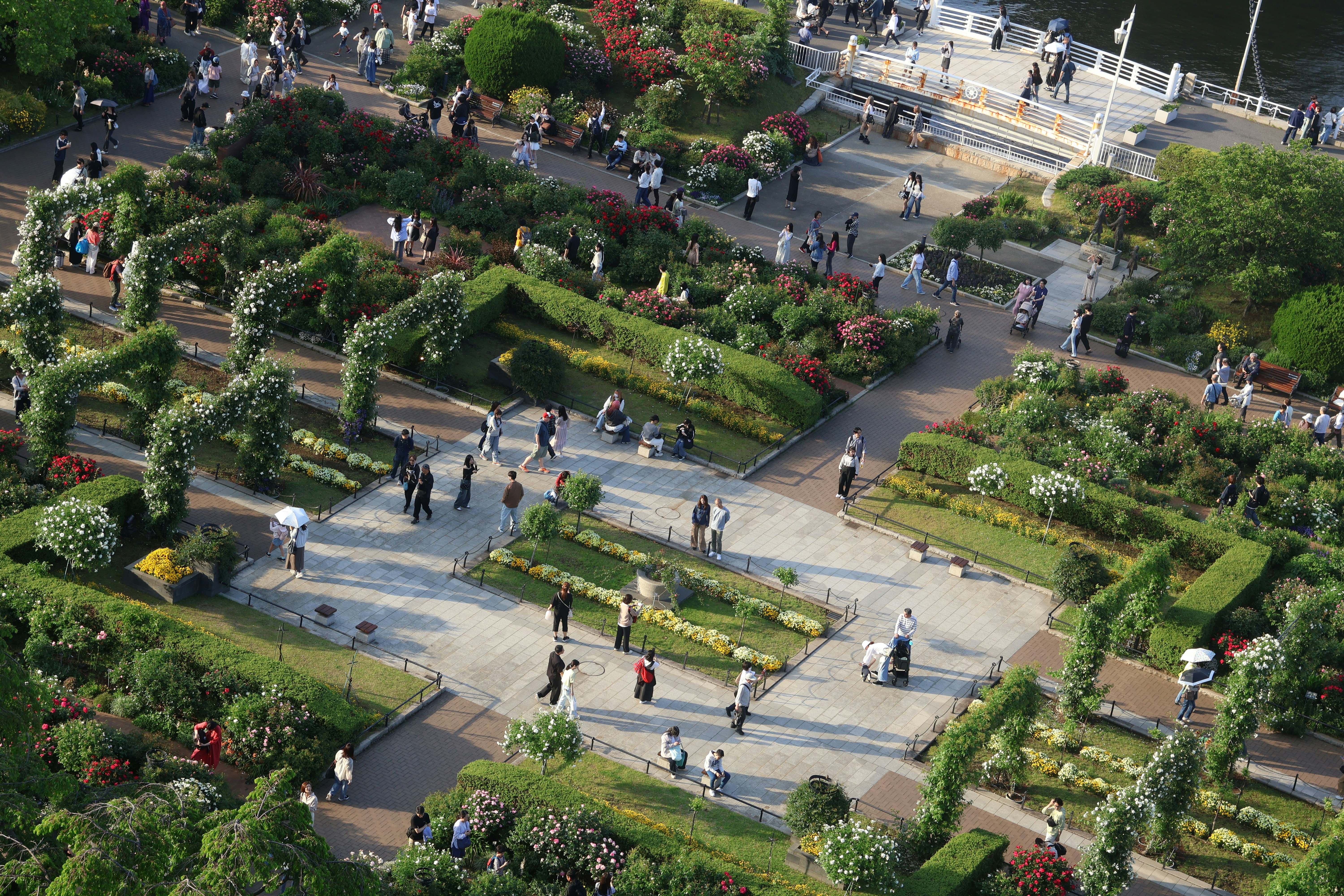 People stroll through a beautiful, lush garden.