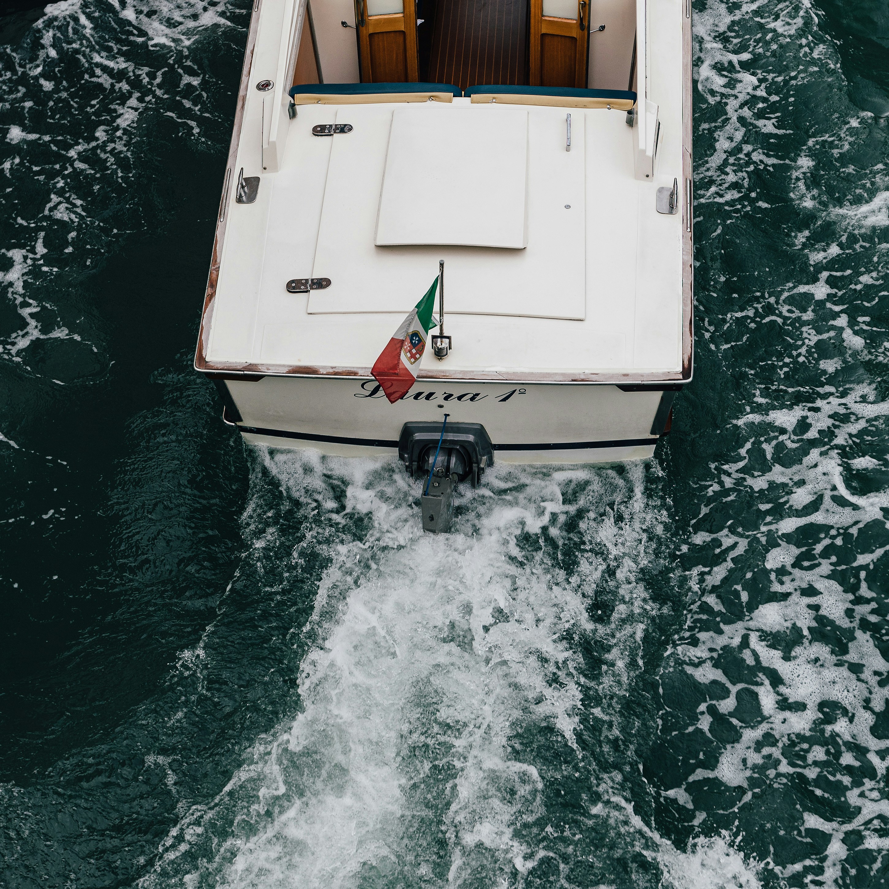 A boat gliding through vibrant waters, showcasing its sleek design and the fluttering Mexican flag. The scene captures the essence of maritime culture.