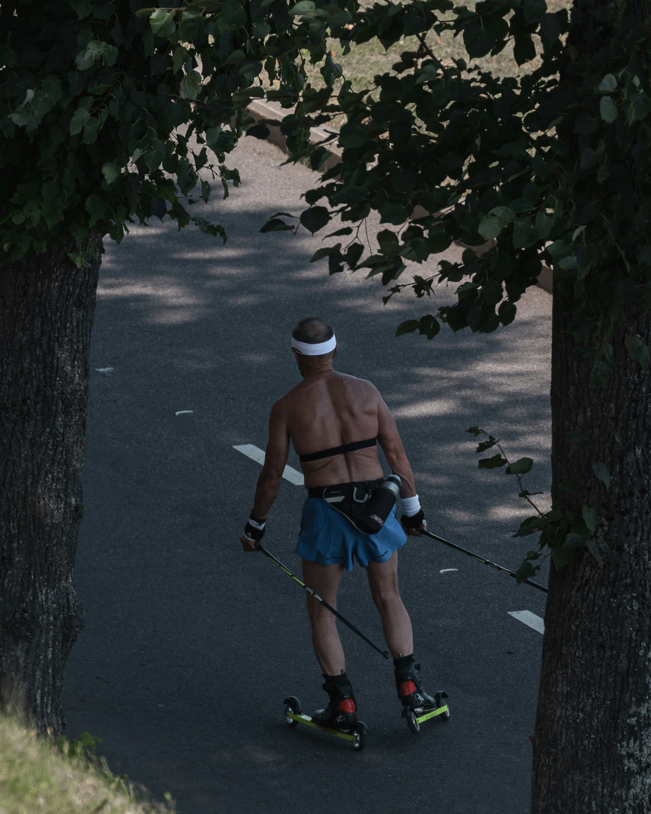 Skier rollerblades down a road.