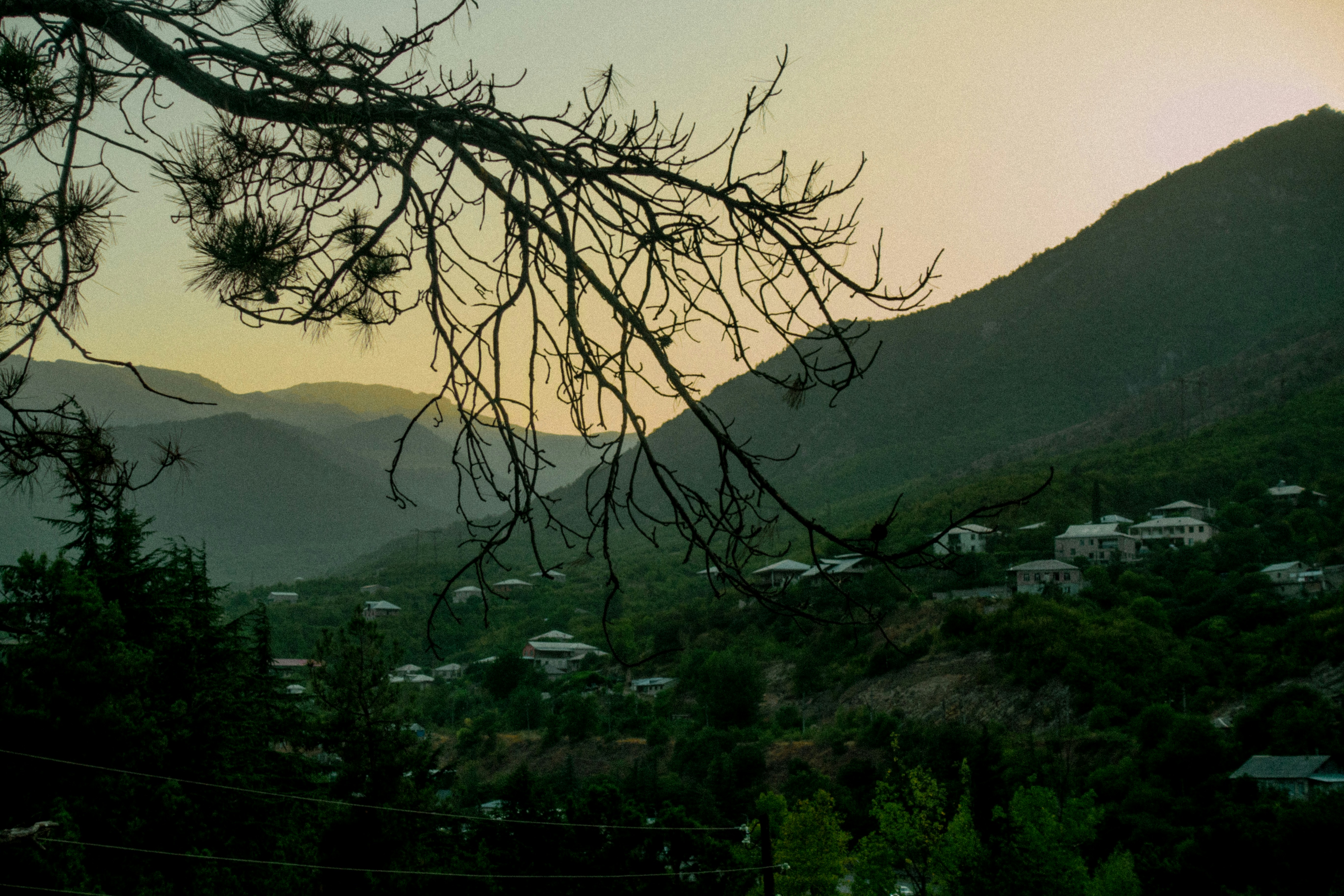 Mountains and houses nestled in the setting sun.