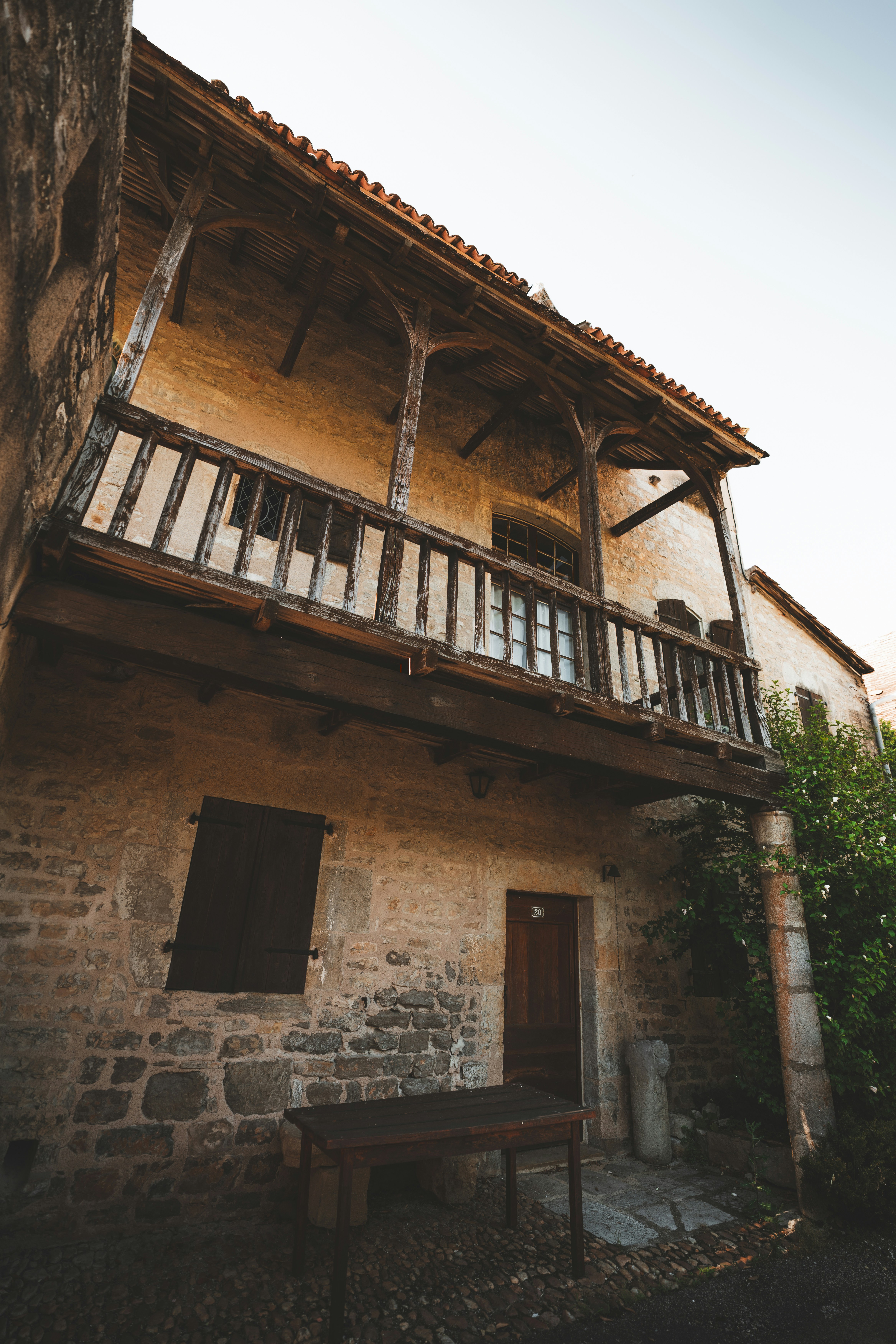 An old stone house features a wooden balcony.