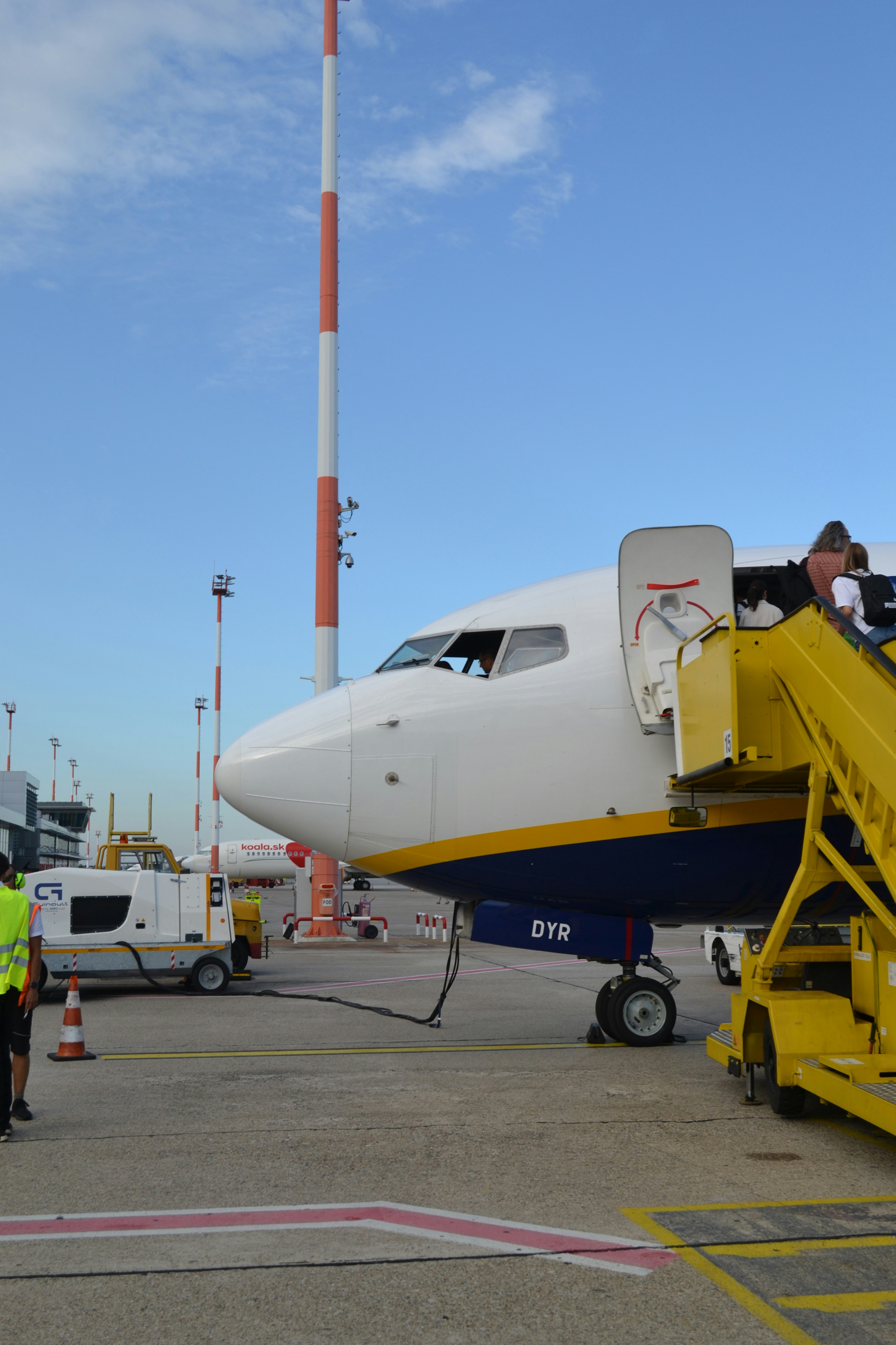 Passengers are boarding a plane on the tarmac.