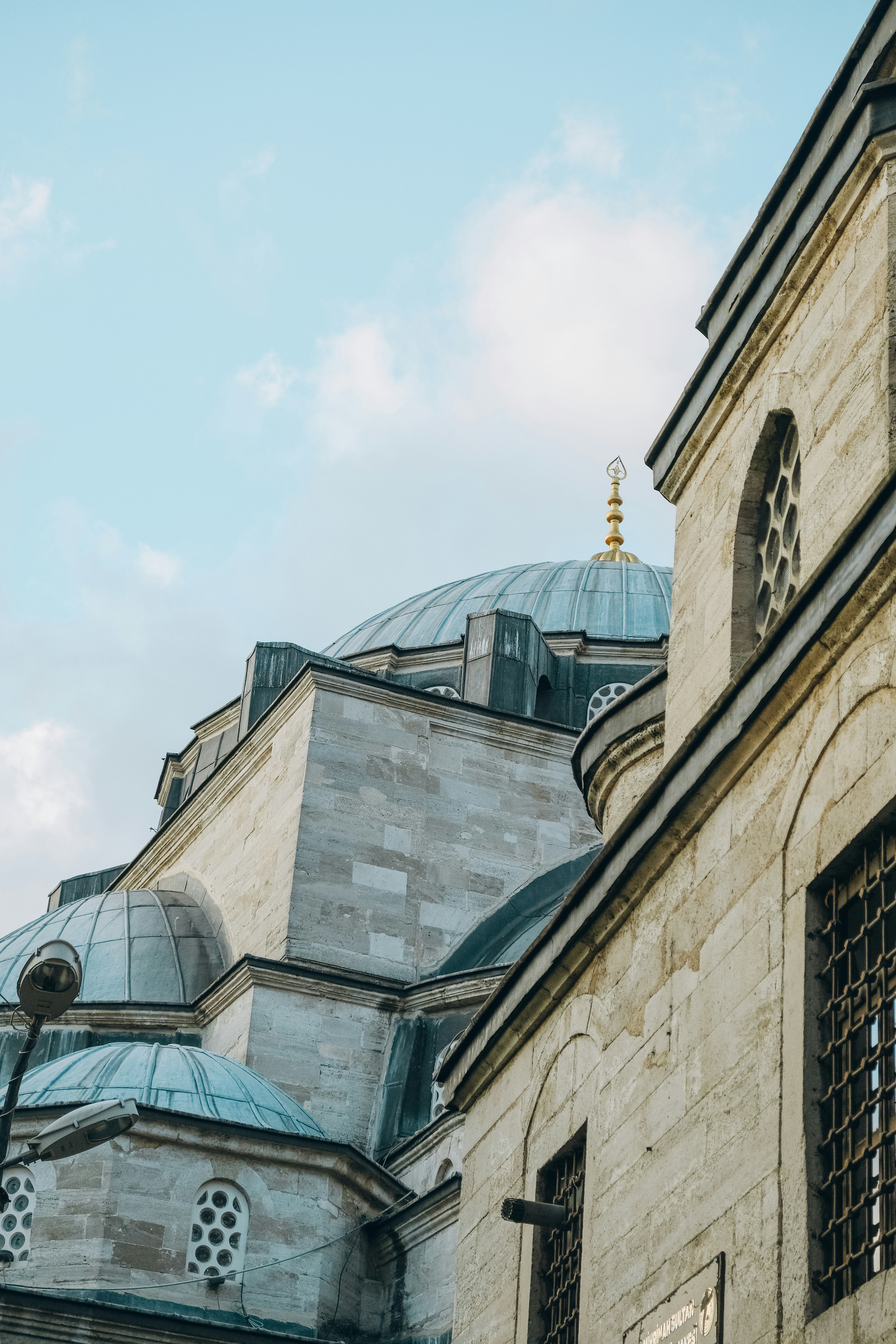 Mosque exterior with domes and a clear sky.