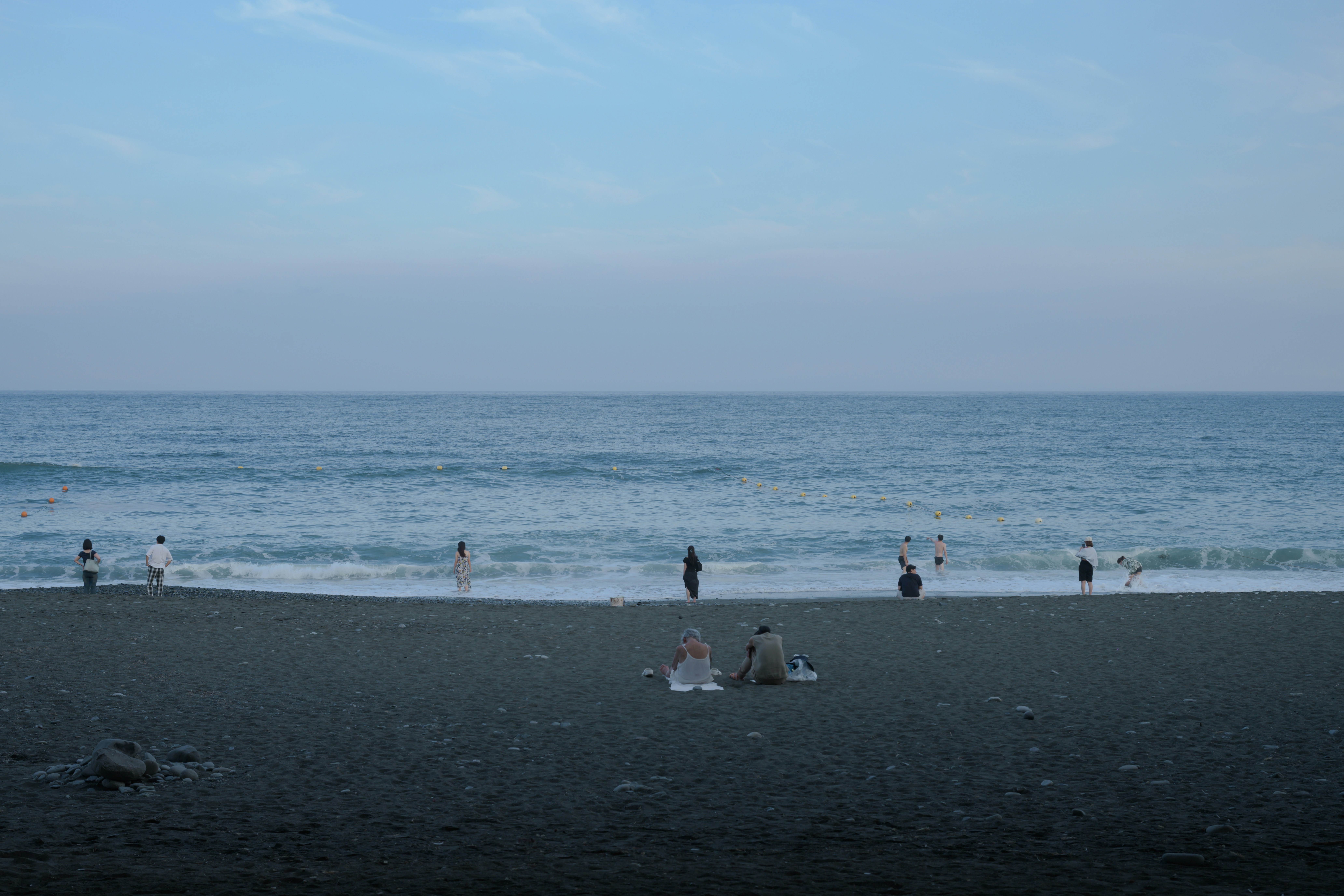 People are enjoying a beach with the ocean.
