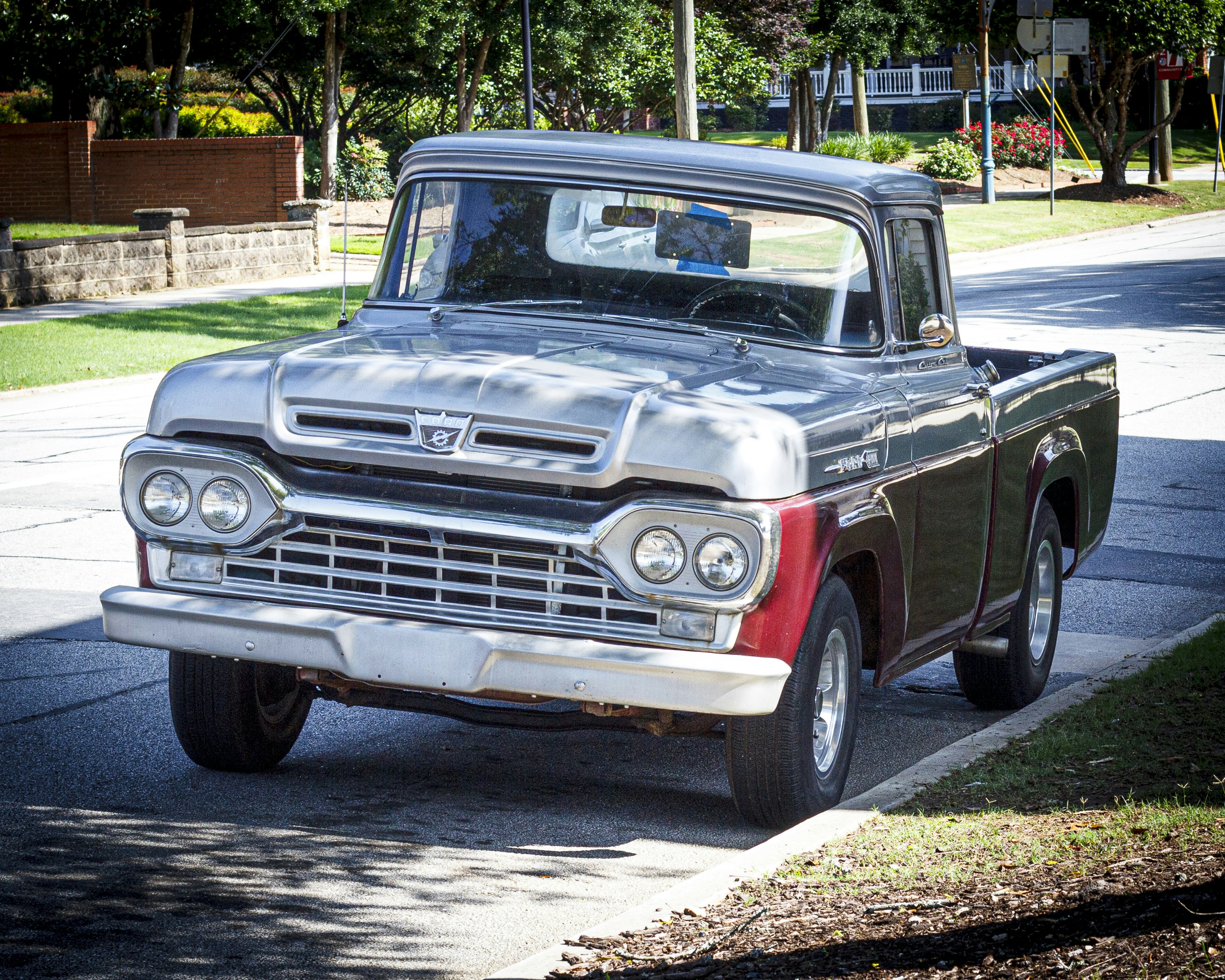 Here is a possible caption: a classic ford pickup truck is parked on the street.