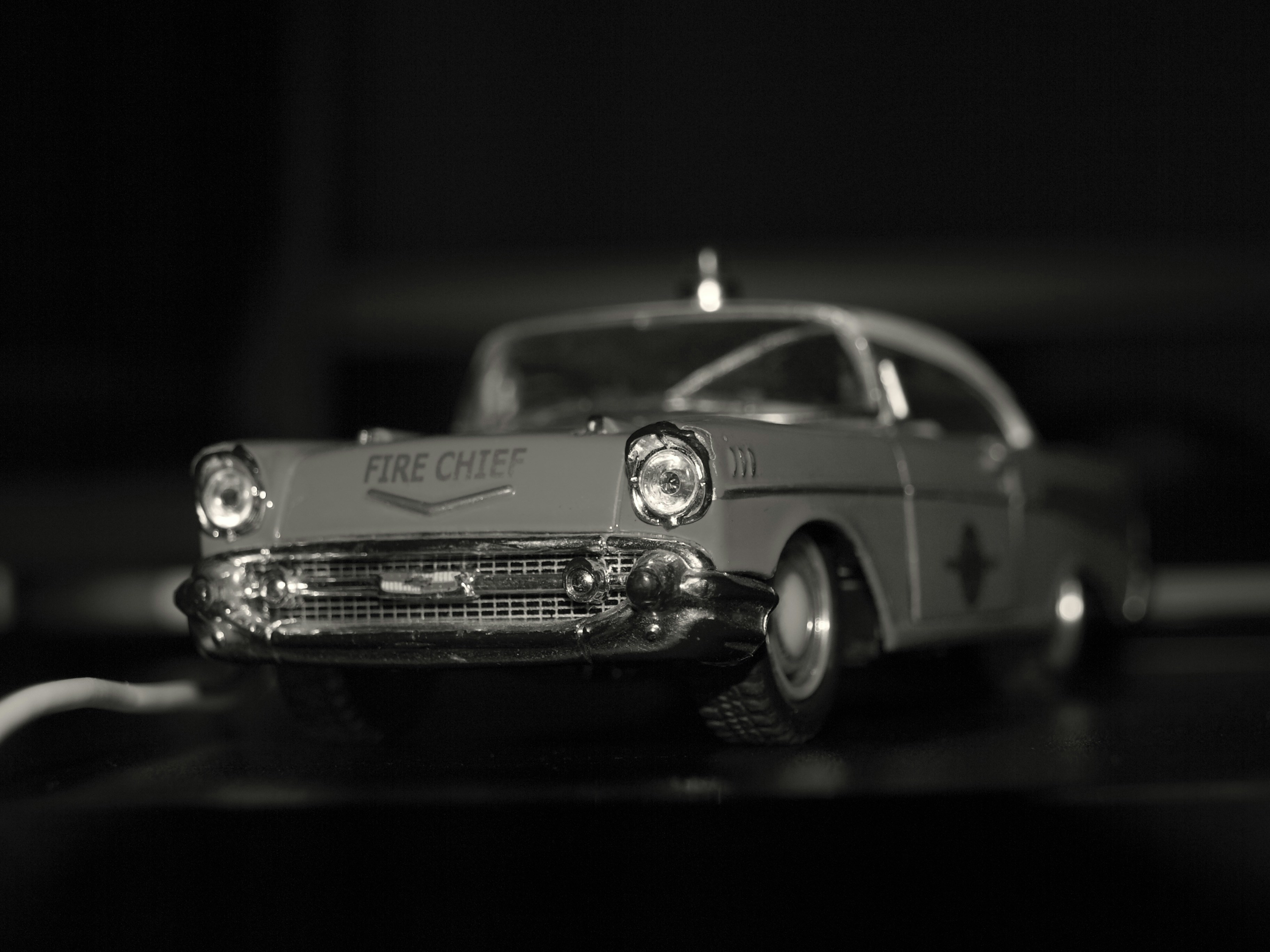 A toy "fire chief" car in grayscale.