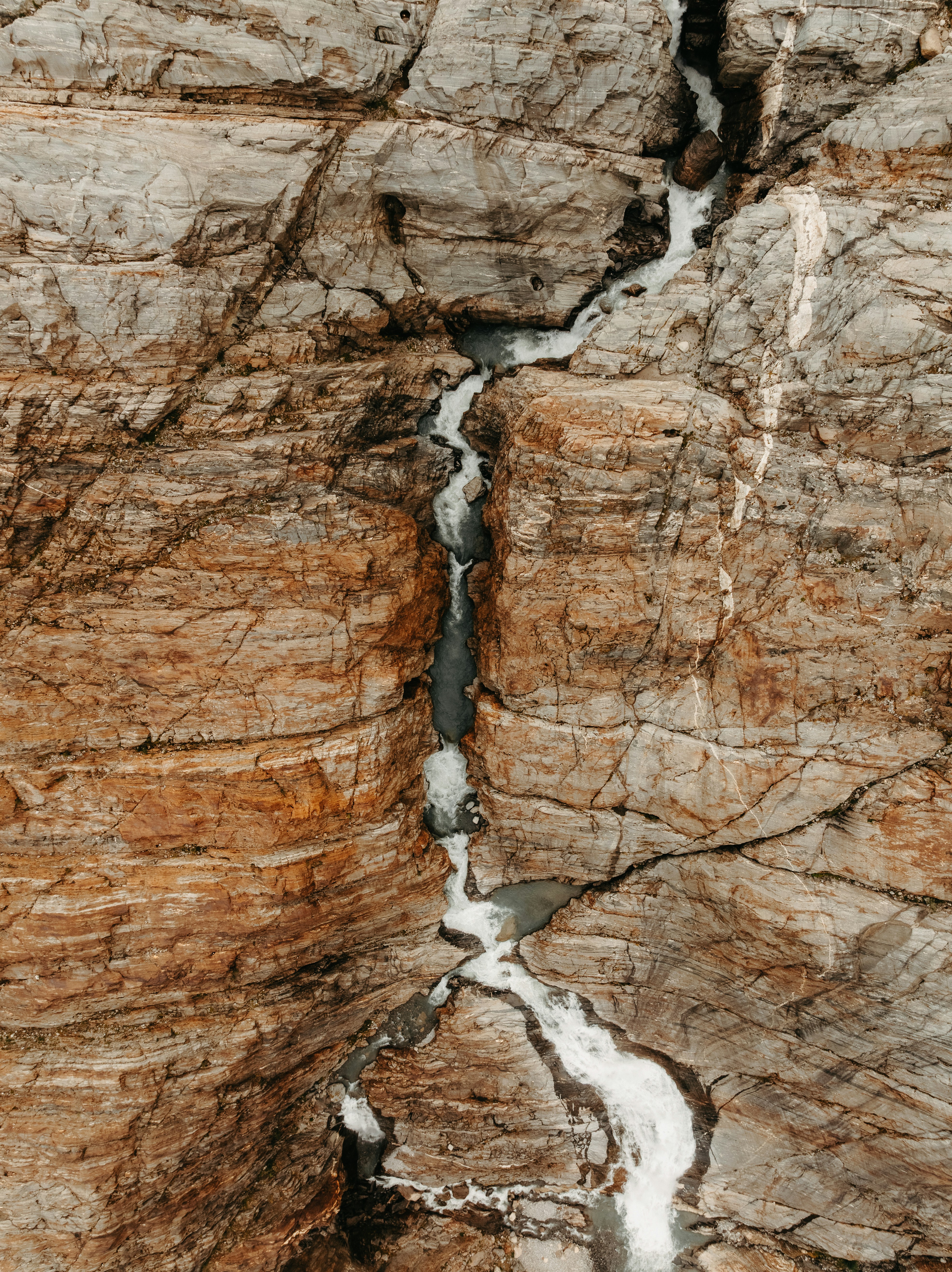 Water flows through a crevice in the rocky cliffside. photo – Free ...