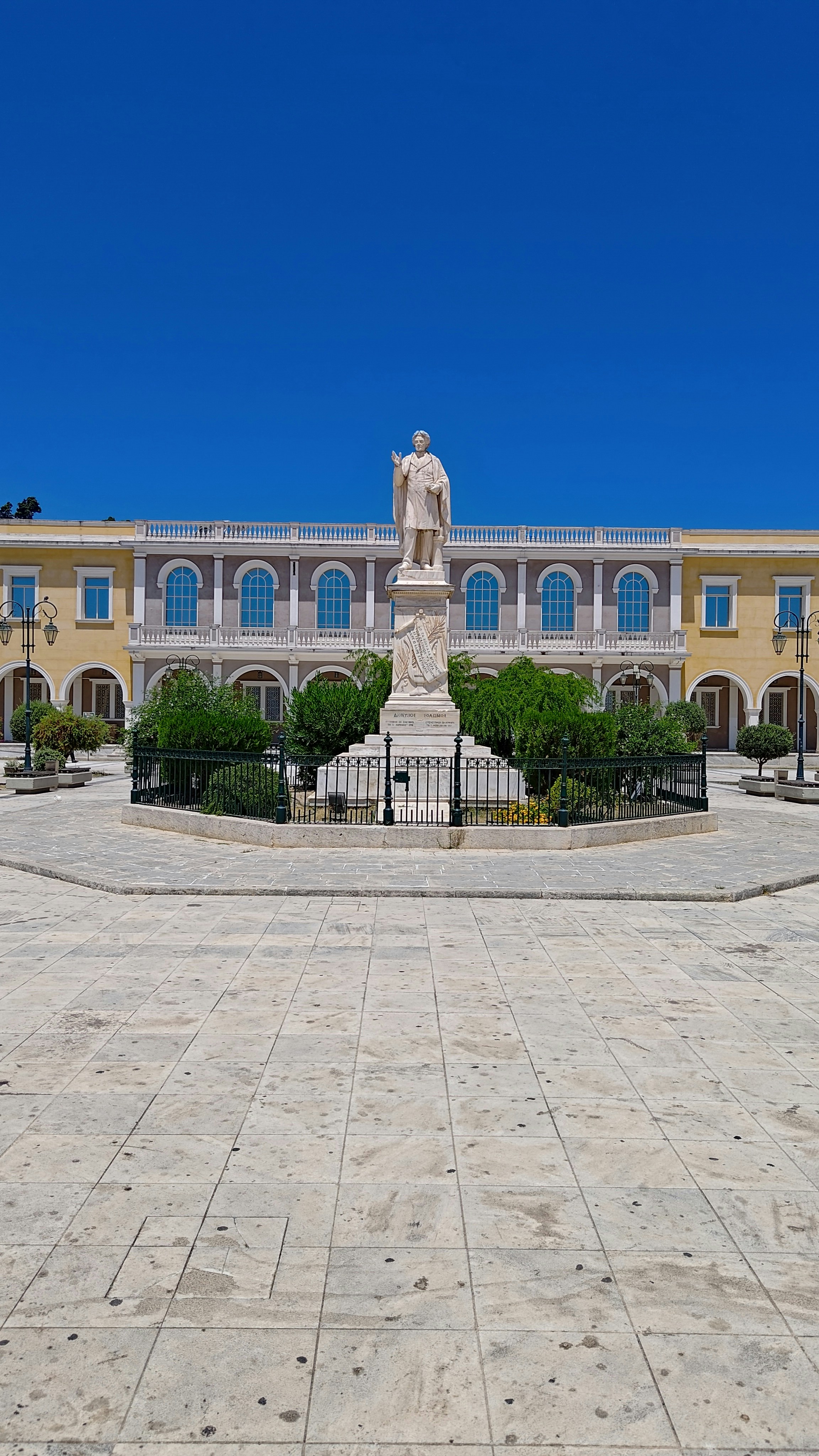 A statue stands in front of a building.