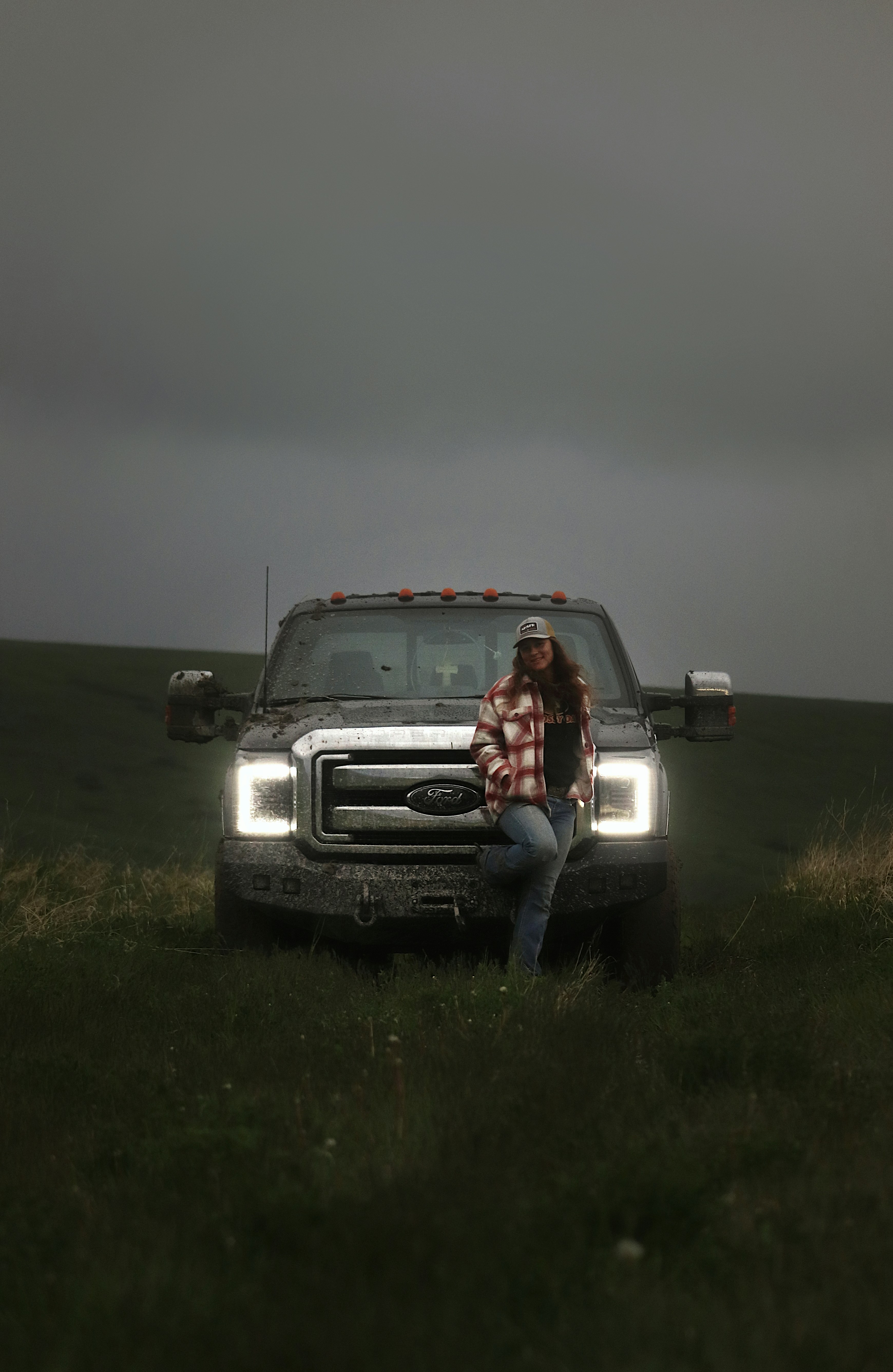 F250 lookin fine stuck in the mud ey? It definitely didn't take us 6 hours to get her out.... | A woman poses with a ford truck.
