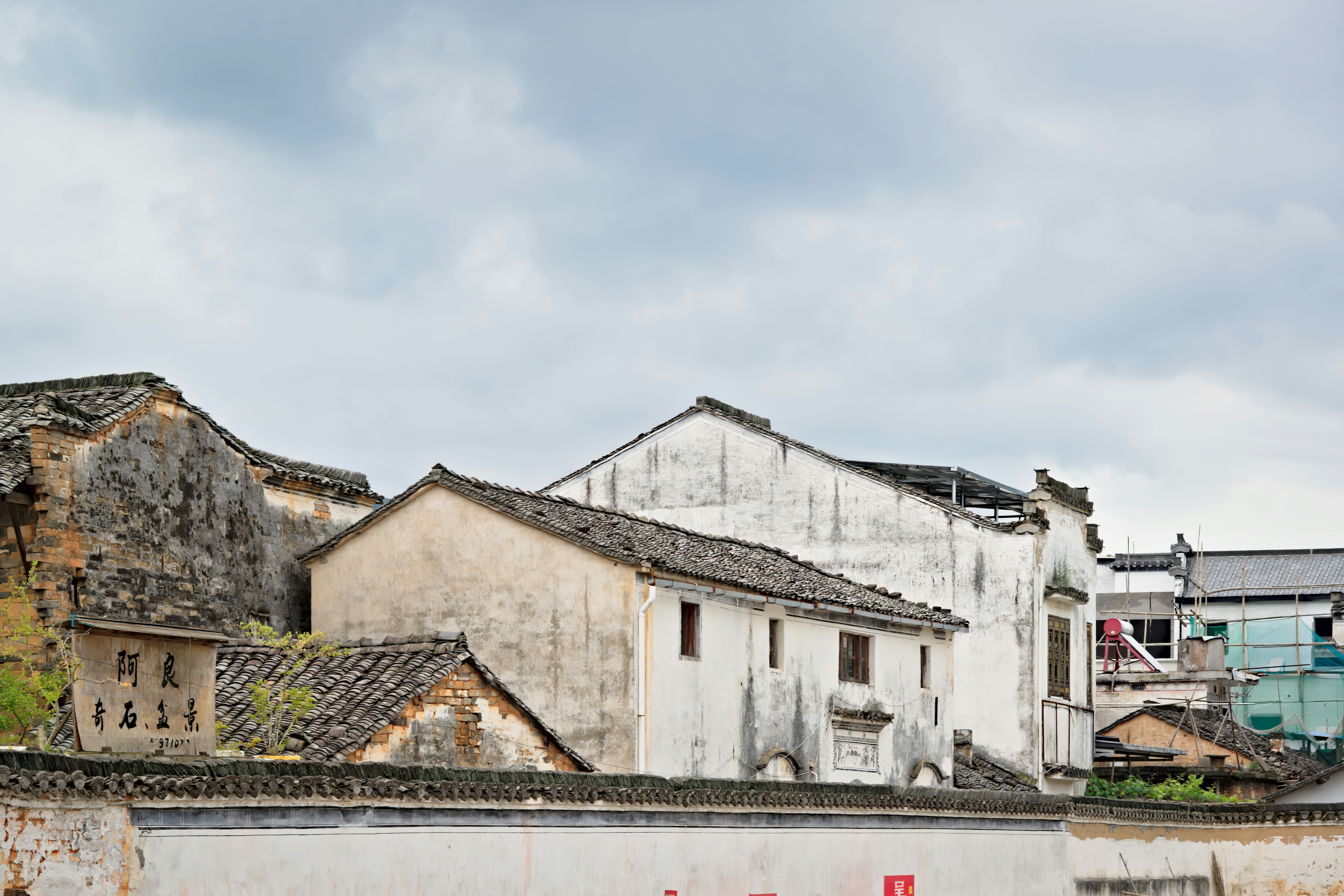 Old houses sit under a cloudy sky.