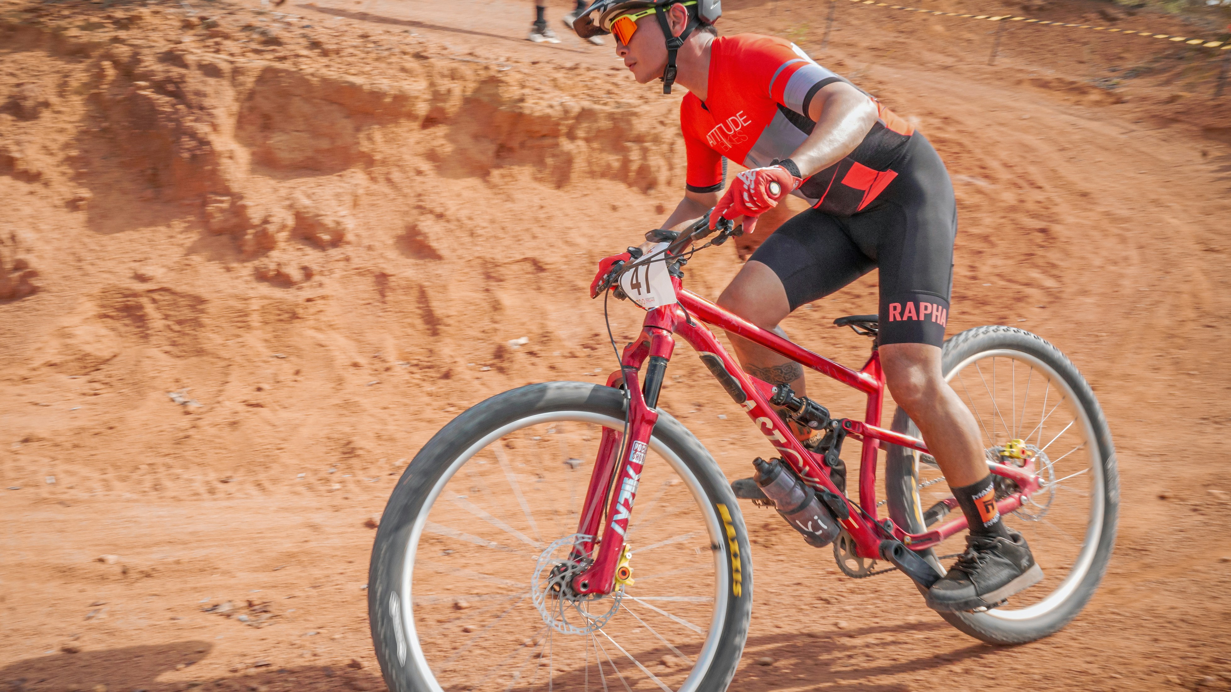 Rider in Red: Mountain Bike Descent Across Desert Terrains