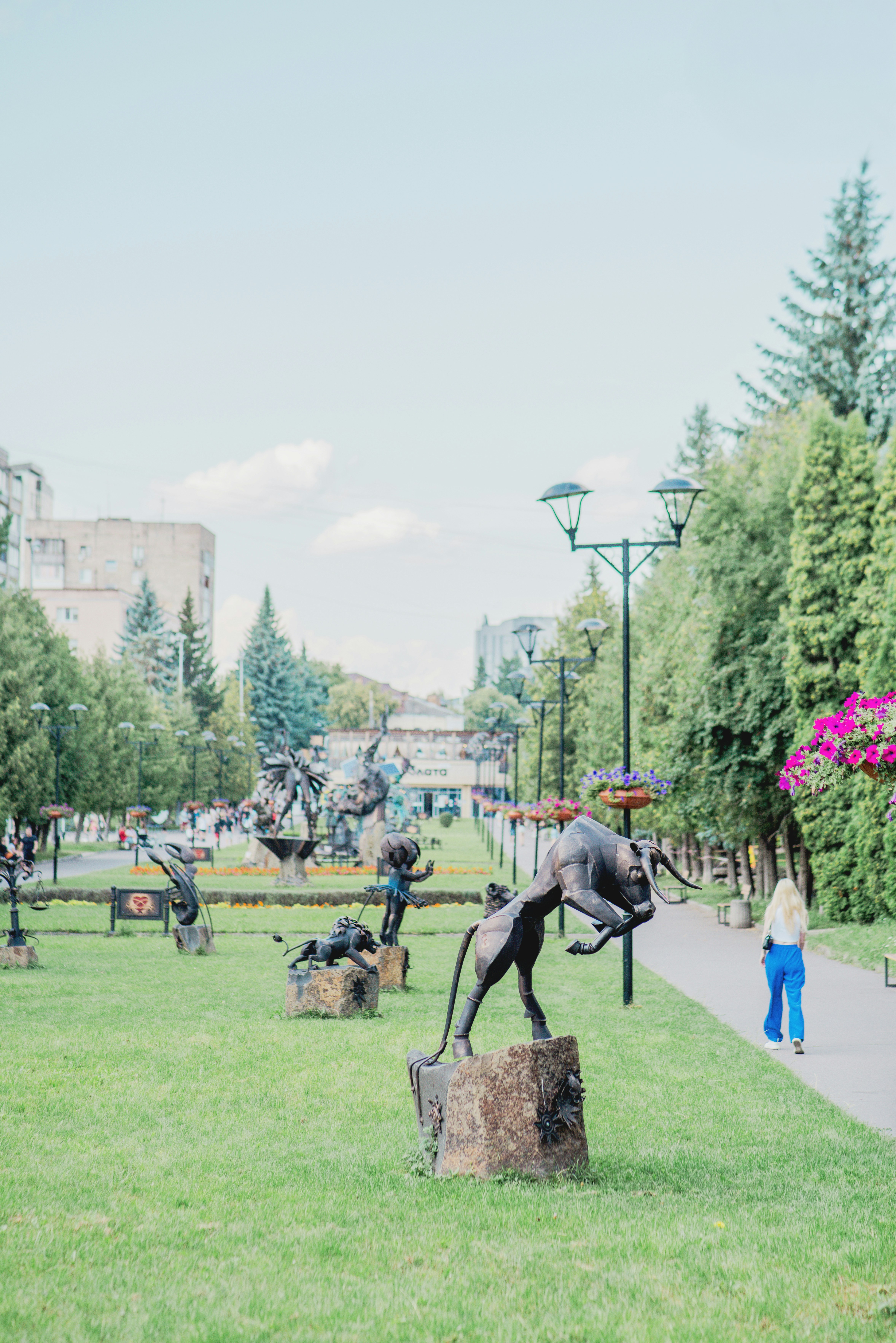 Park with bronze statues on a sunny day.