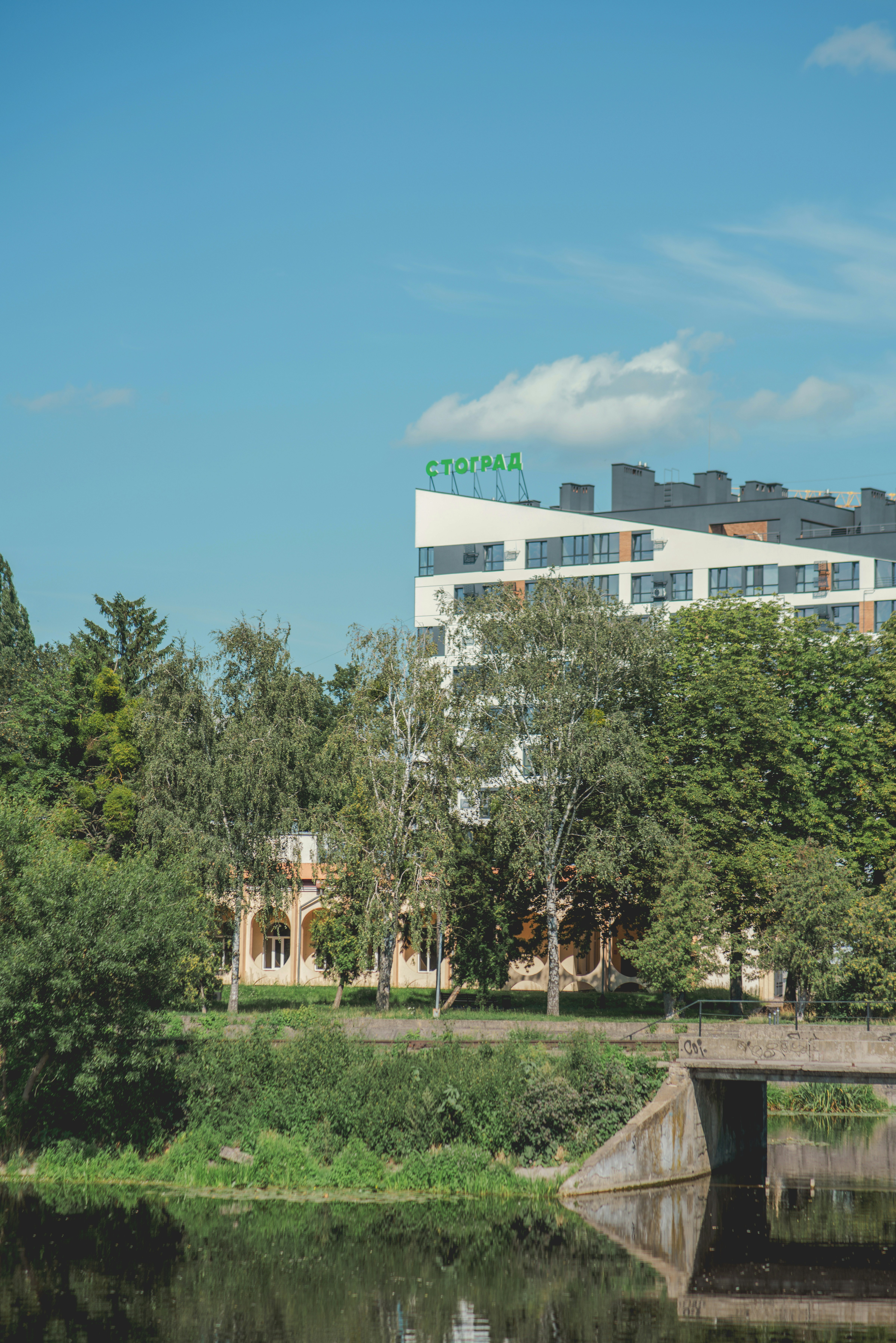 A modern building stands near a calm river.