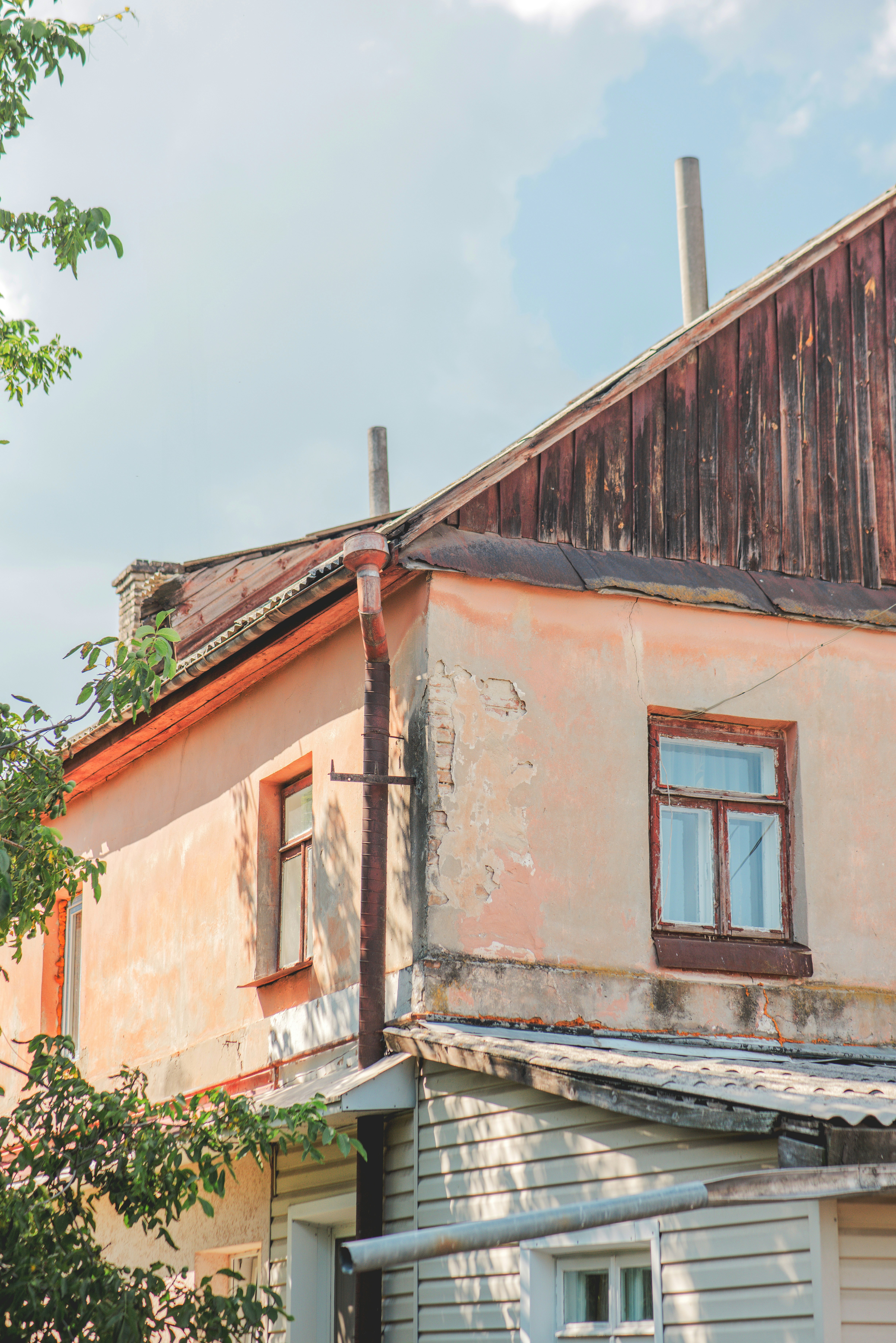 Old house with weathered paint against a blue sky.
