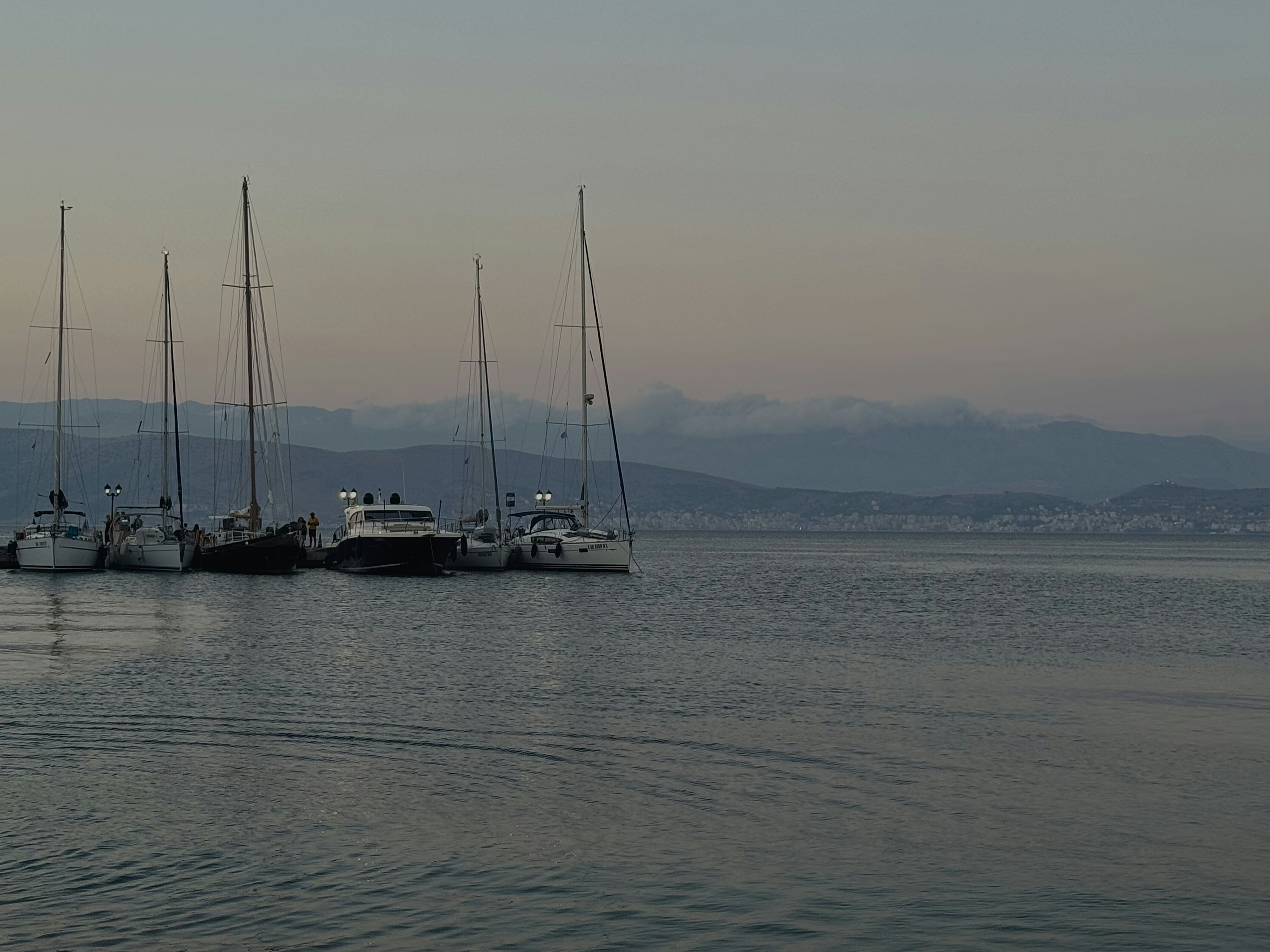 Boats are docked at the harbor at twilight.