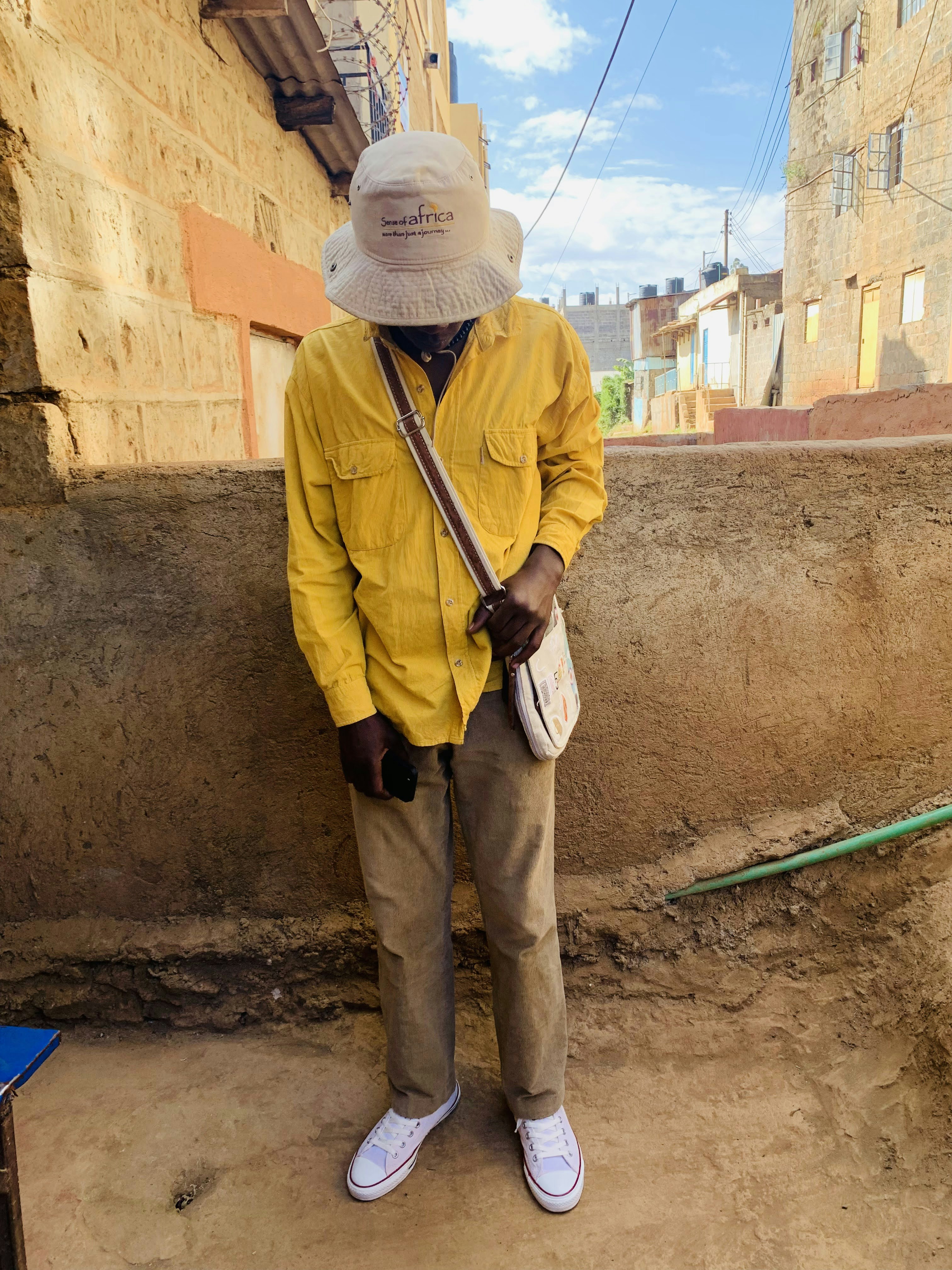 A person stands in the street wearing yellow.