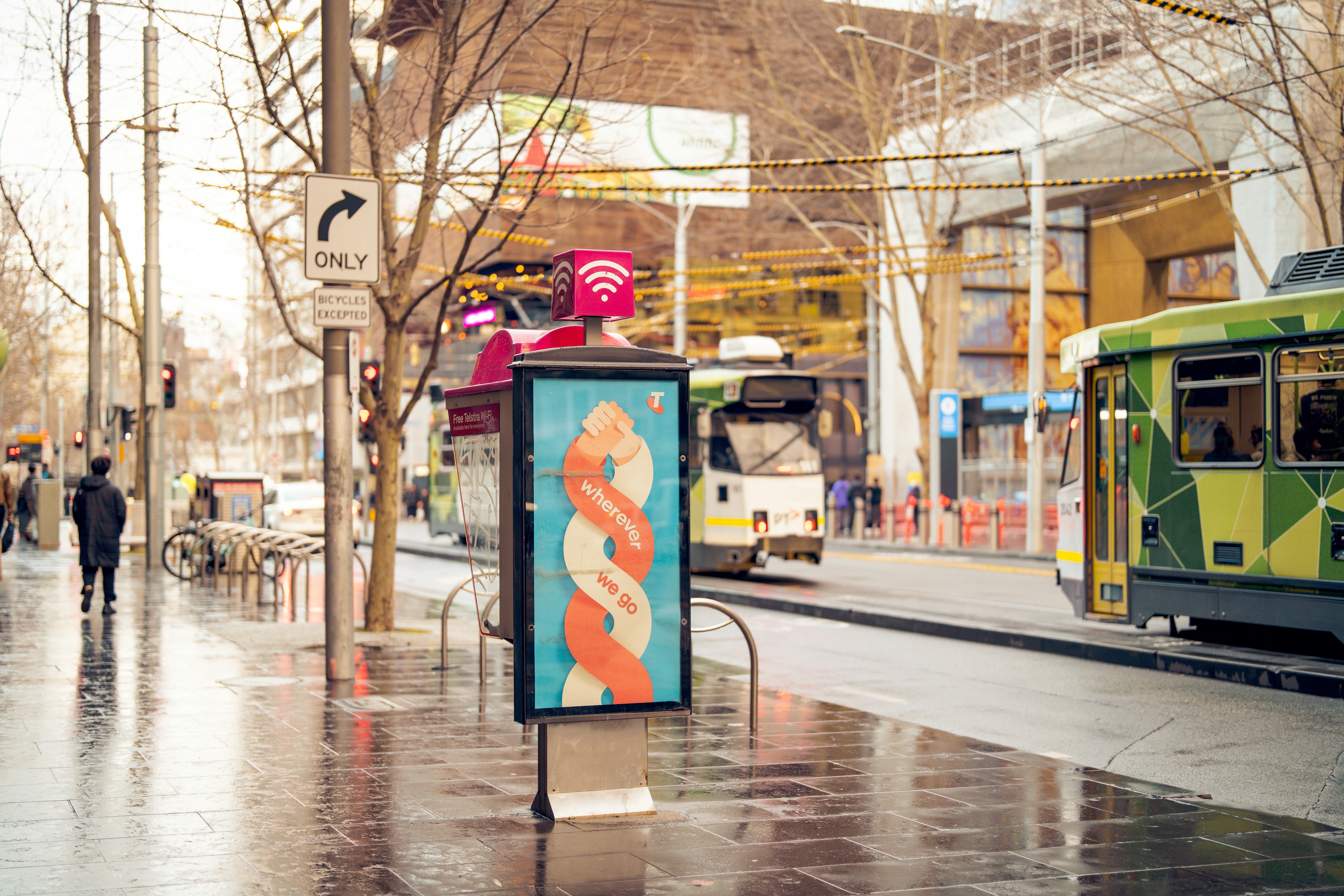 A city street scene with trams and signs.