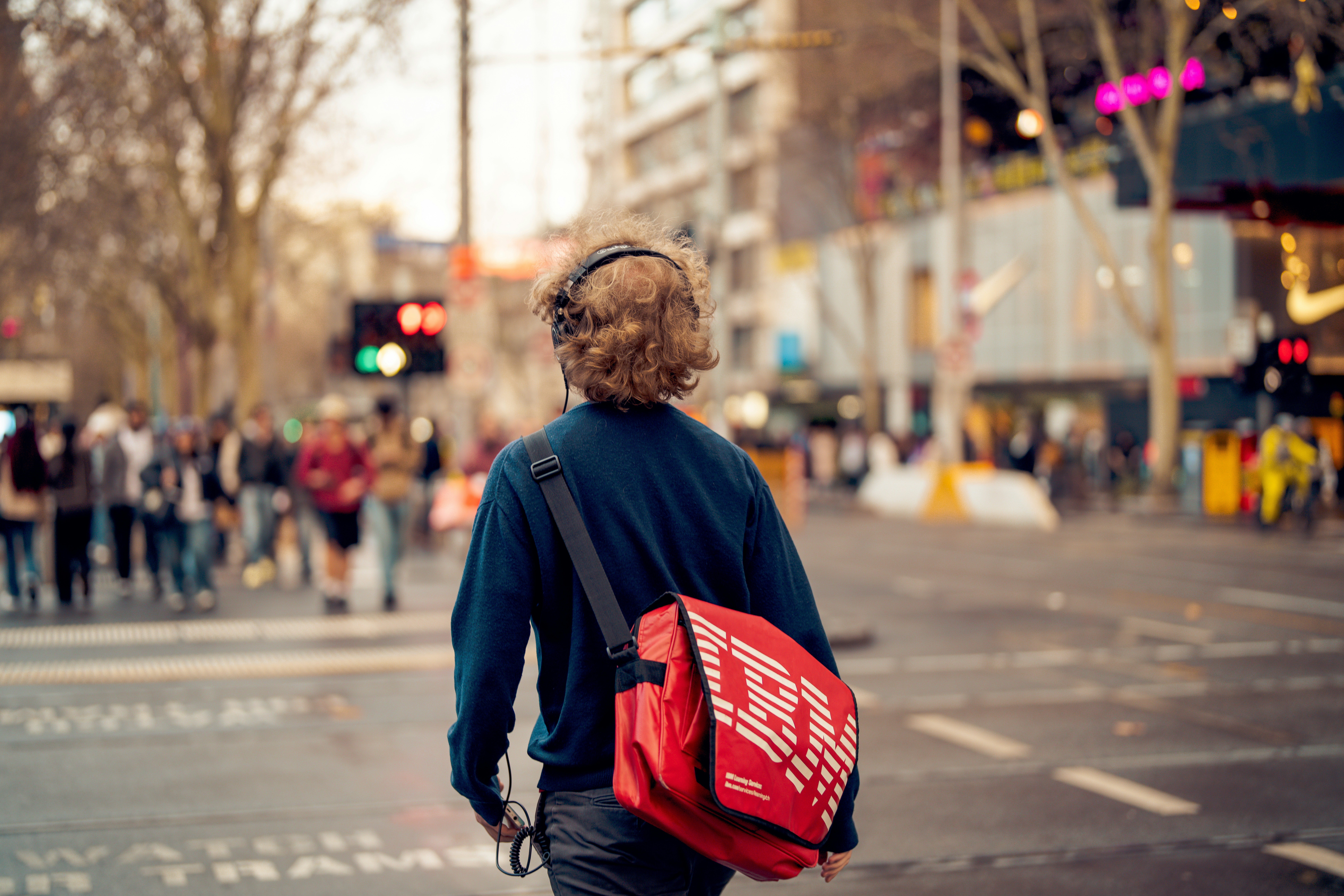 Person walking in the street with a bag.