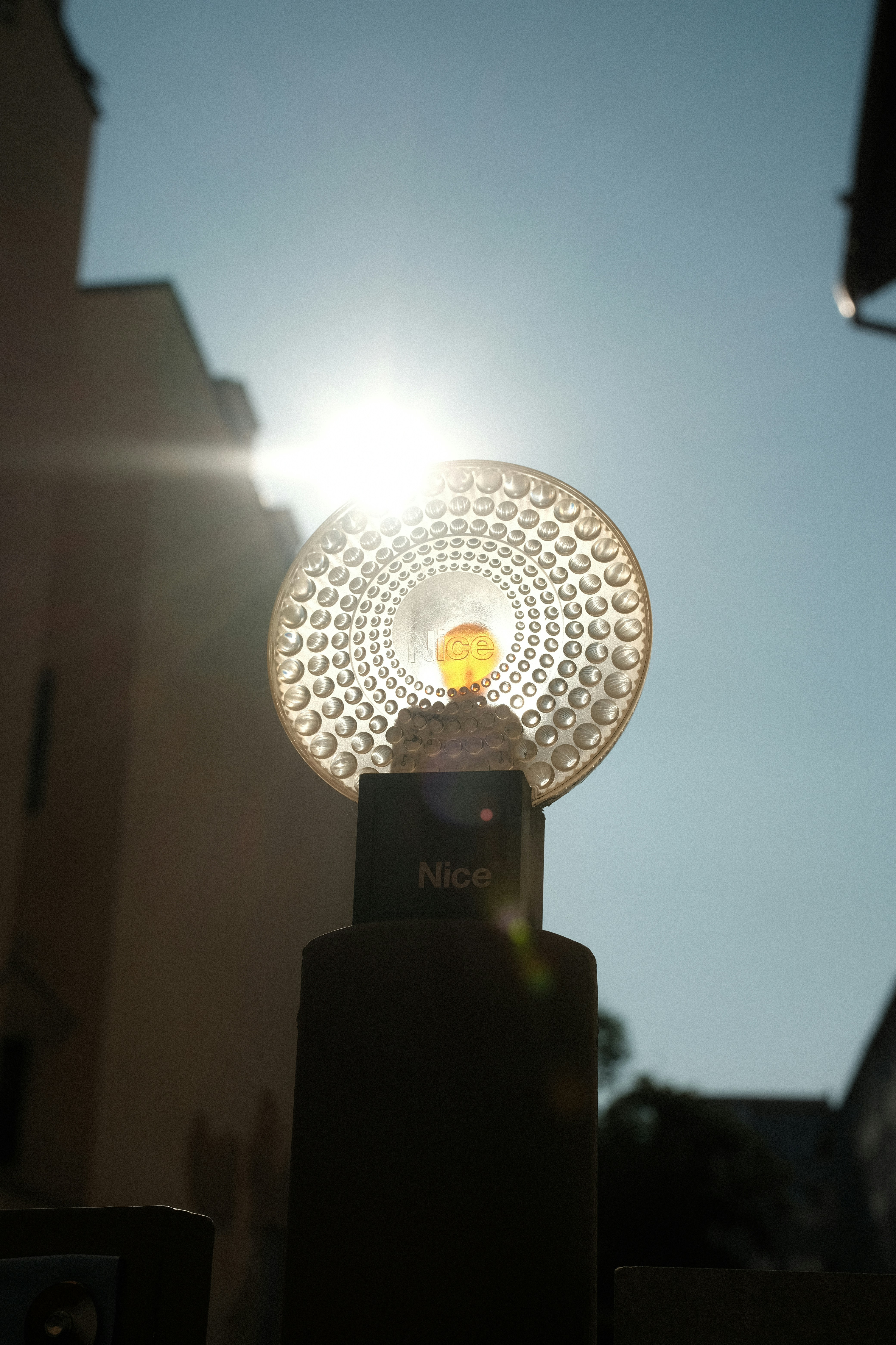 Lamp silhouette against clear sky during sunset | The sun shines behind a unique street lamp.