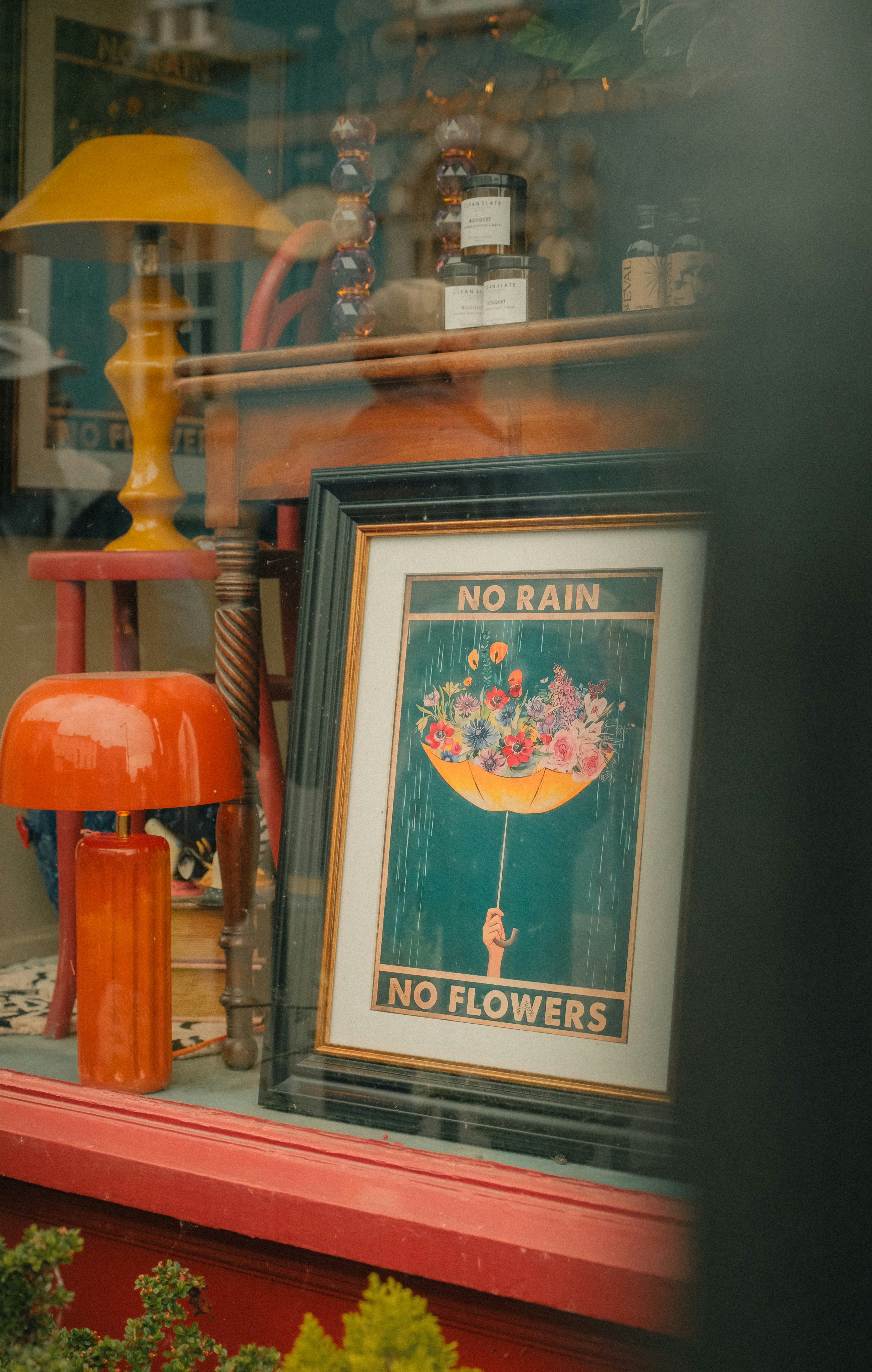 A shop window displays a poster and lamps.