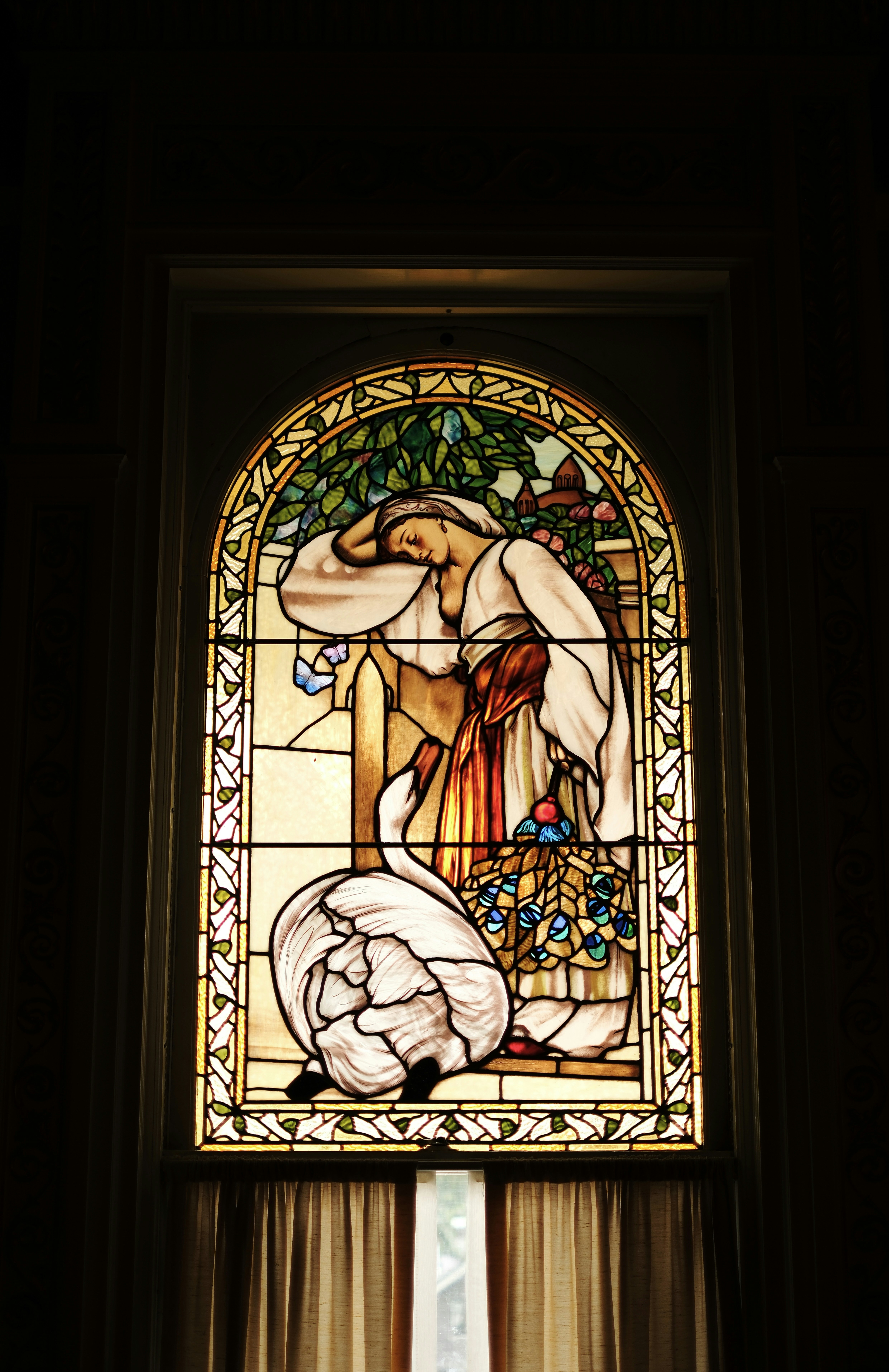 Instagram - @kaprion | A stained-glass window depicts a woman and a swan.
