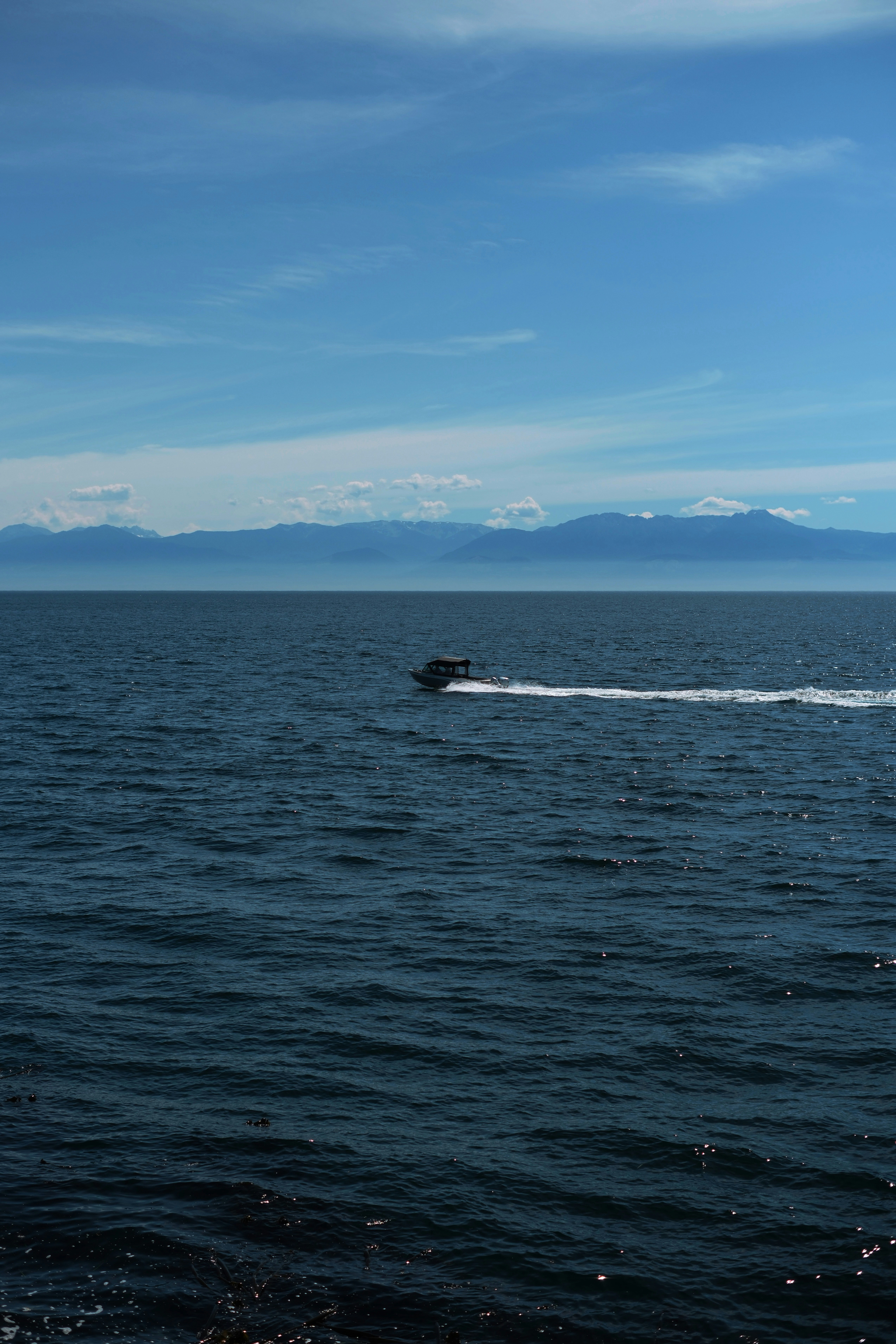 Instagram - @kaprion | A boat speeds across the ocean, towards the horizon.
